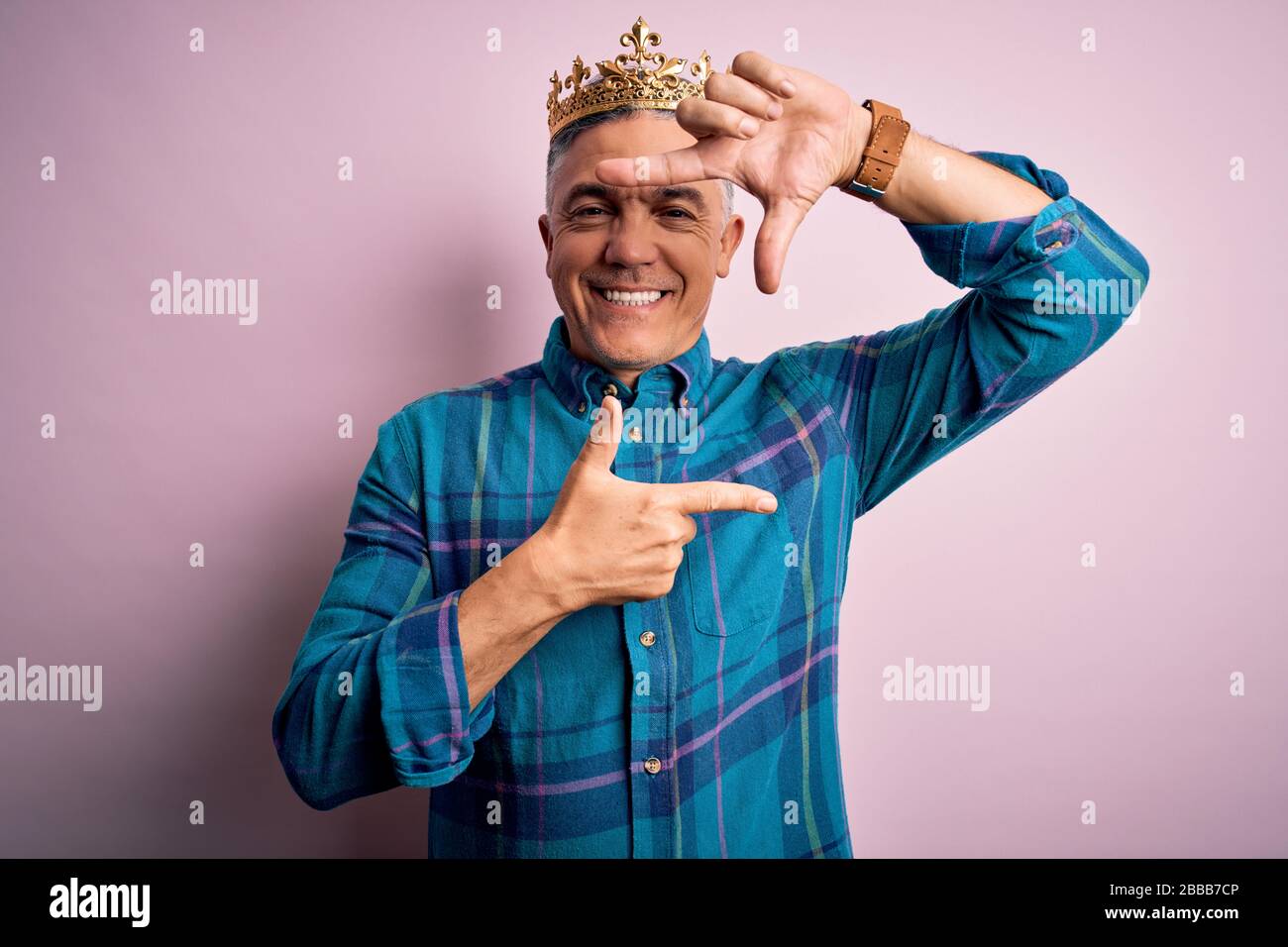 Middle age handsome grey-haired man wearing golden crown of king over ...