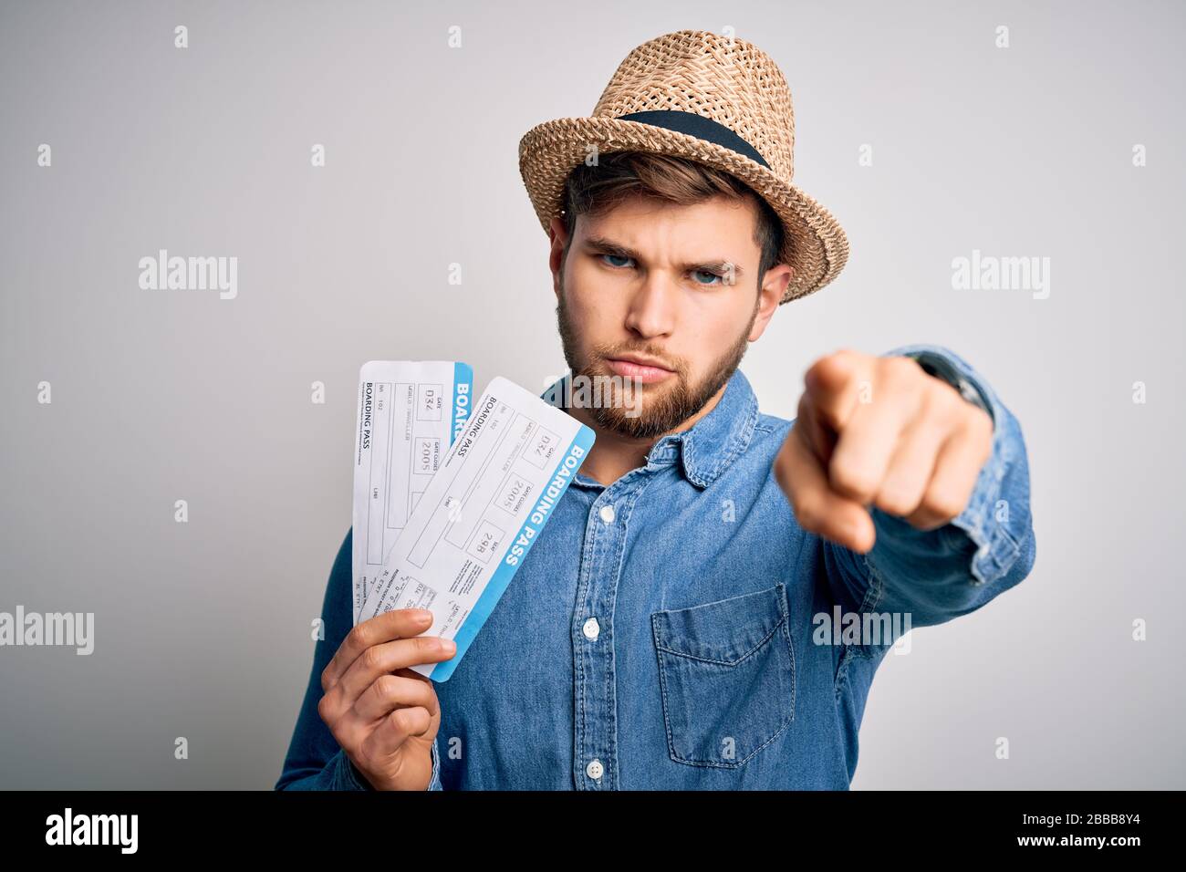 Young blond tourist man with blue eyes on vacation wearing hat holding ...