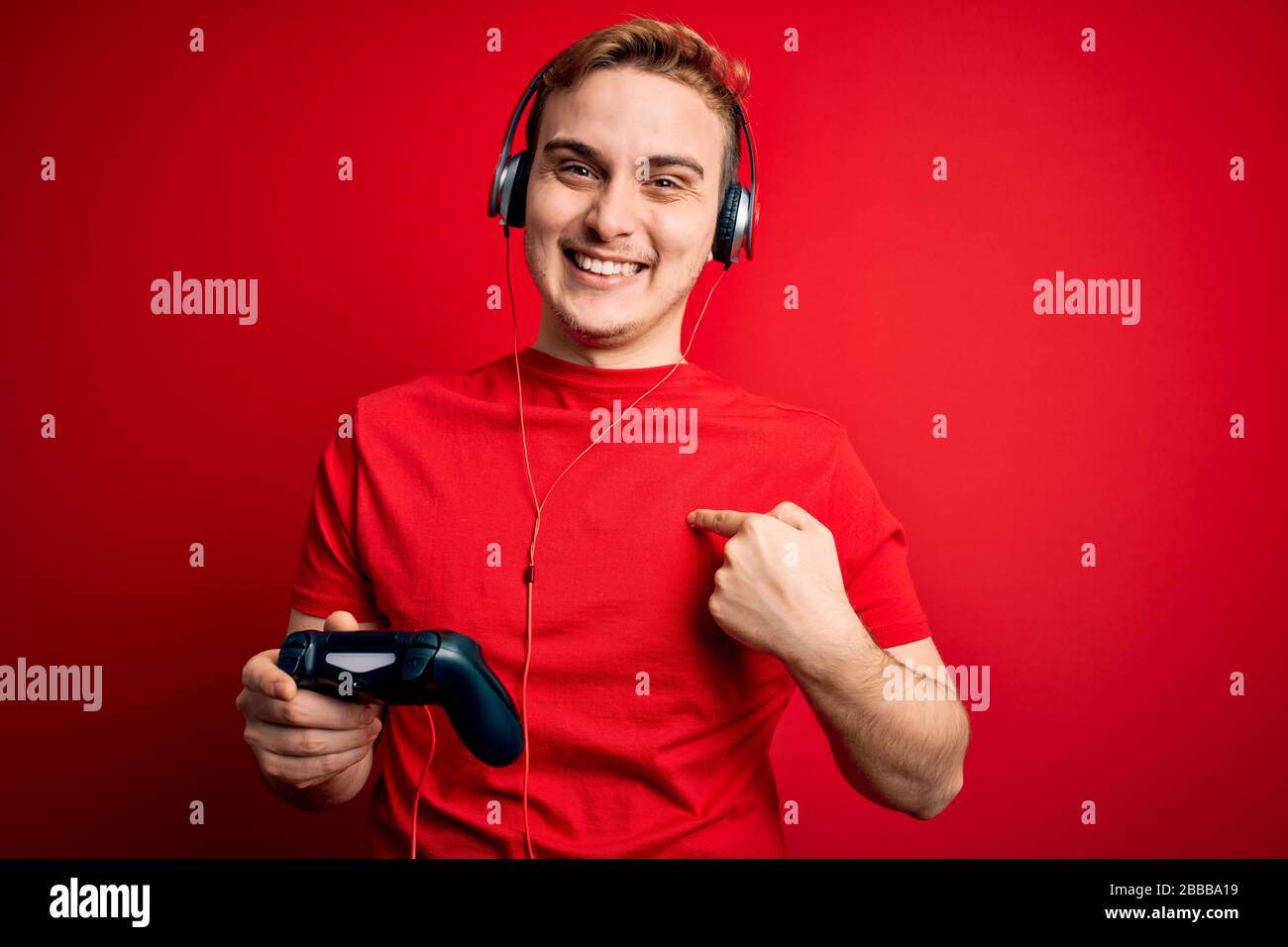 Young handsome redhead gamer man playing video game using headphones ...
