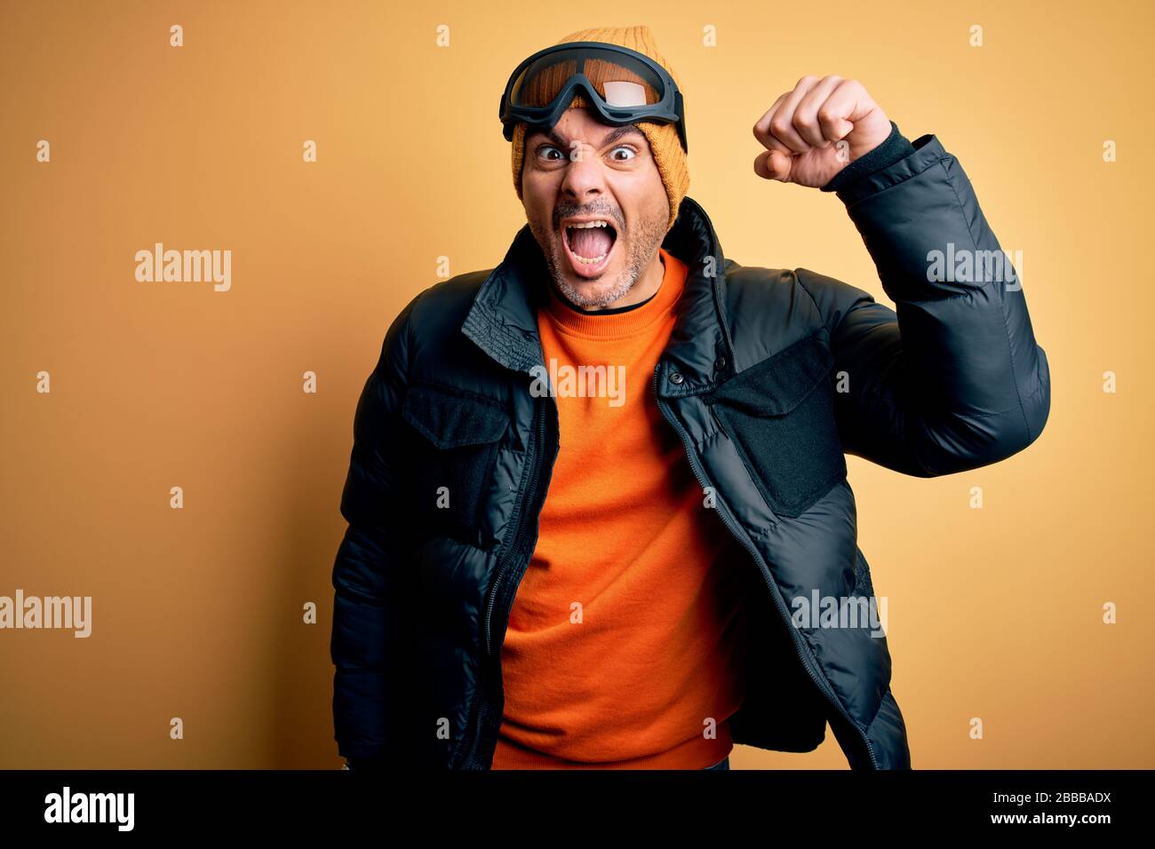 Young handsome skier man skiing wearing snow sportswear using ski ...