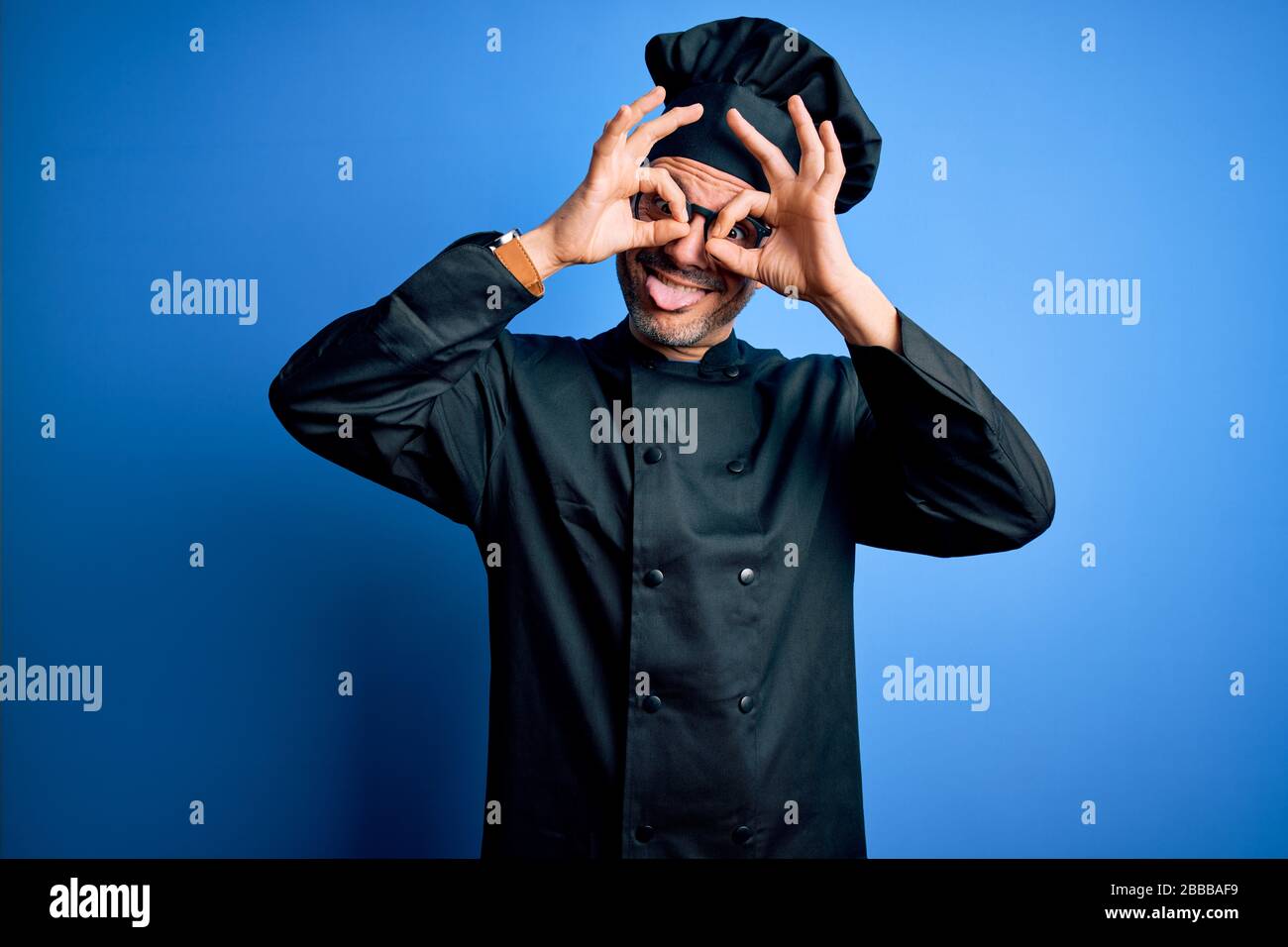Young handsome chef man wearing cooker uniform and hat over isolated ...
