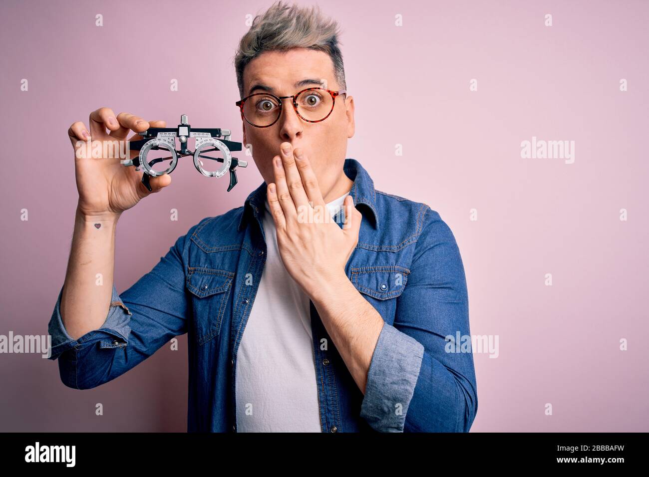 Young modern optical optomestrist man holding optometrical glasses over ...