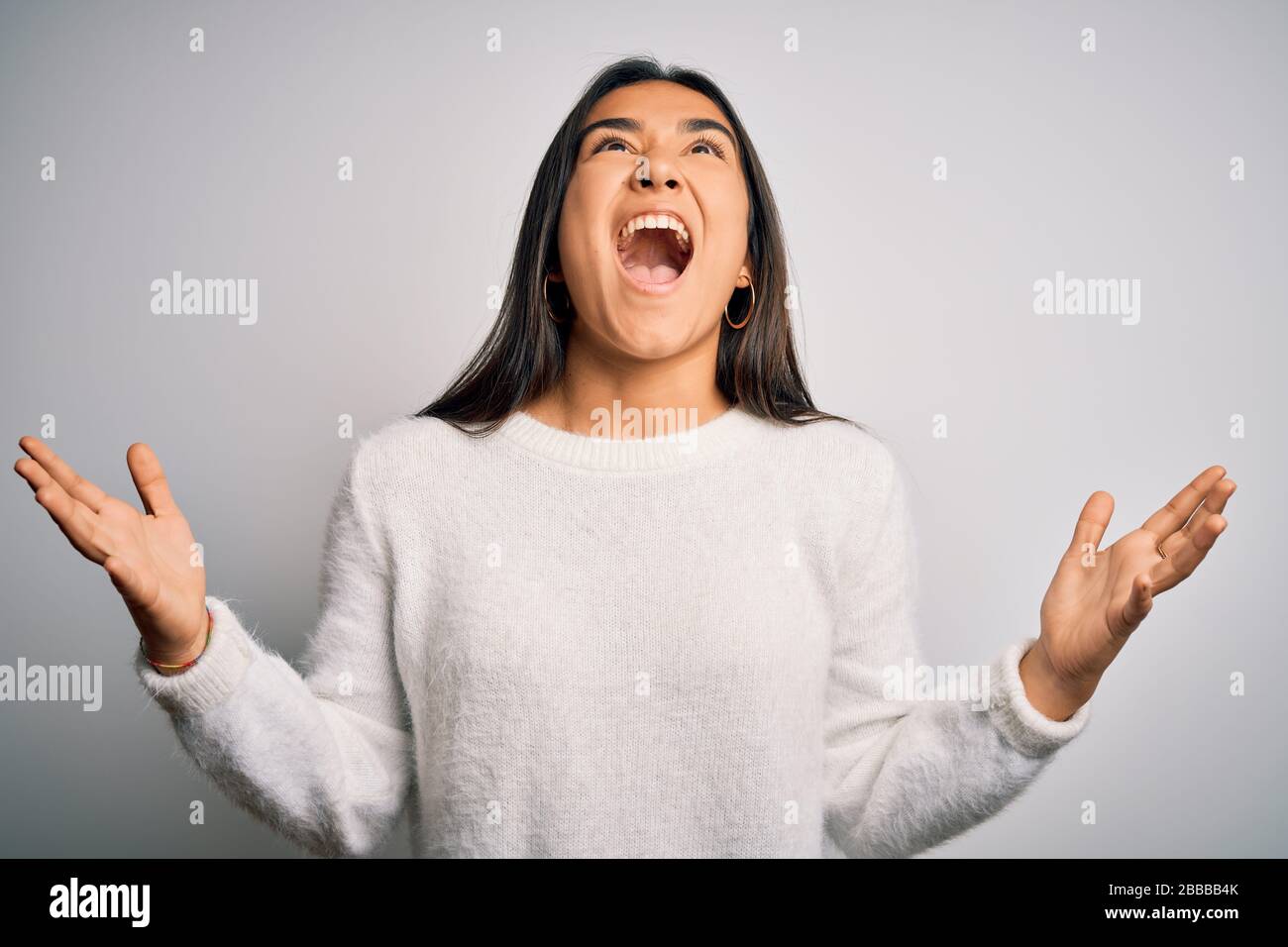 Young beautiful asian woman wearing casual sweater standing over white ...