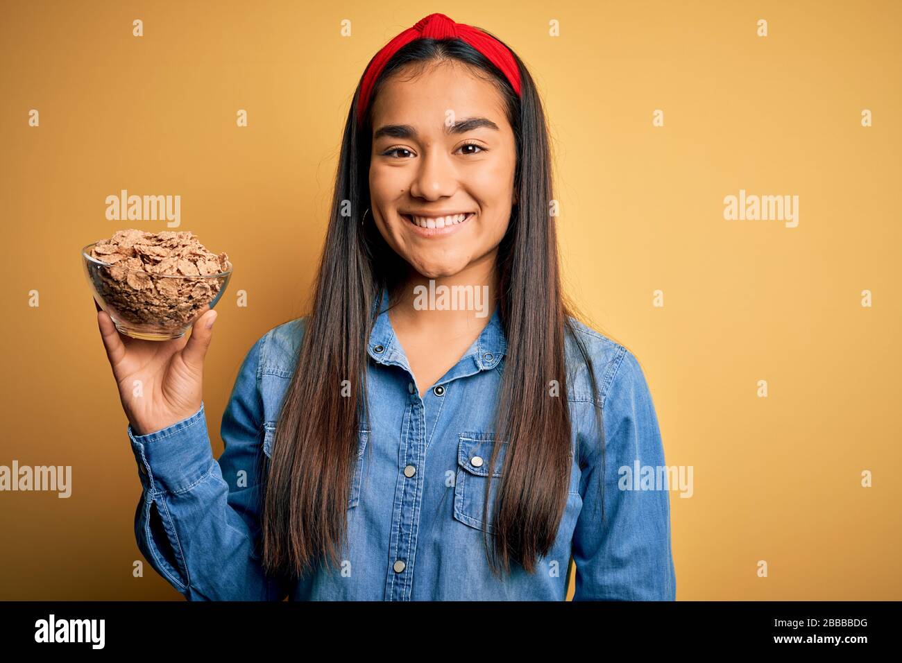 Beautiful asian woman holding bowl with healthy corn flakes cereals ...