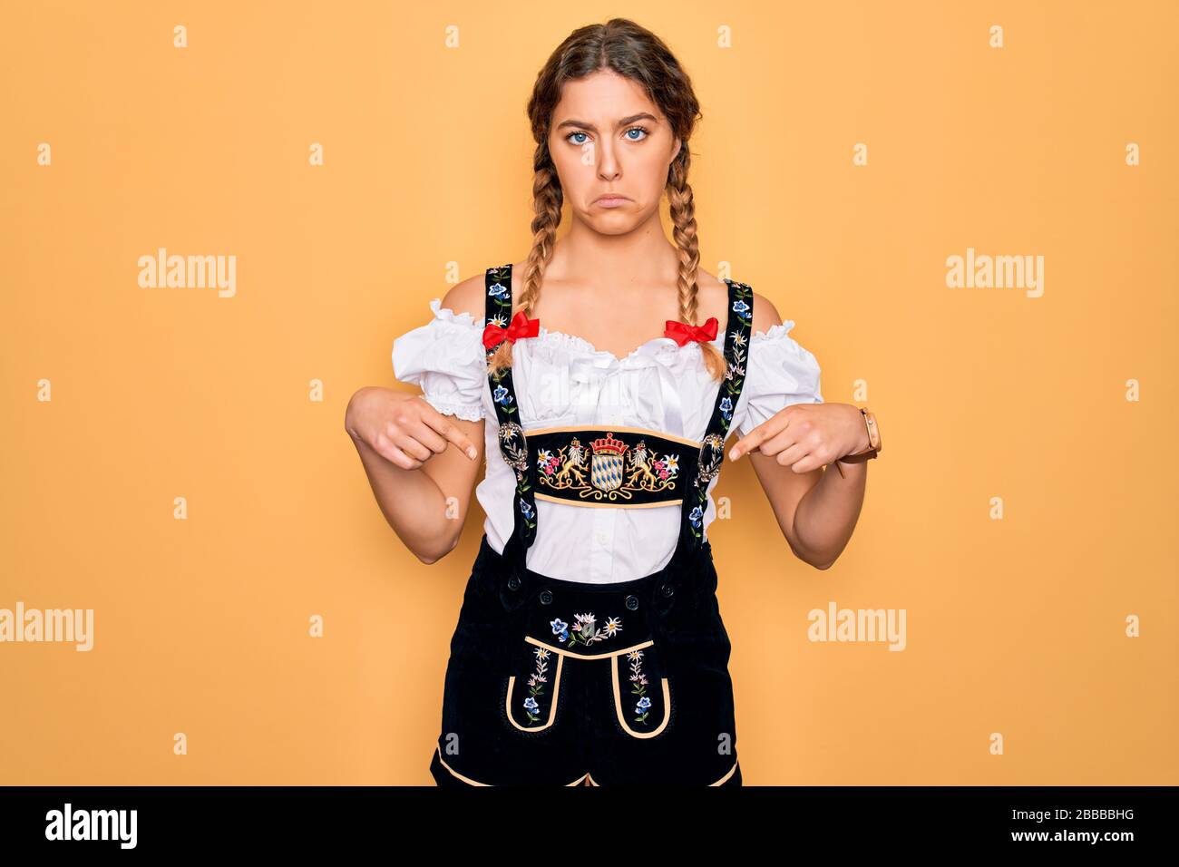 Young beautiful blonde german woman with blue eyes wearing traditional ...