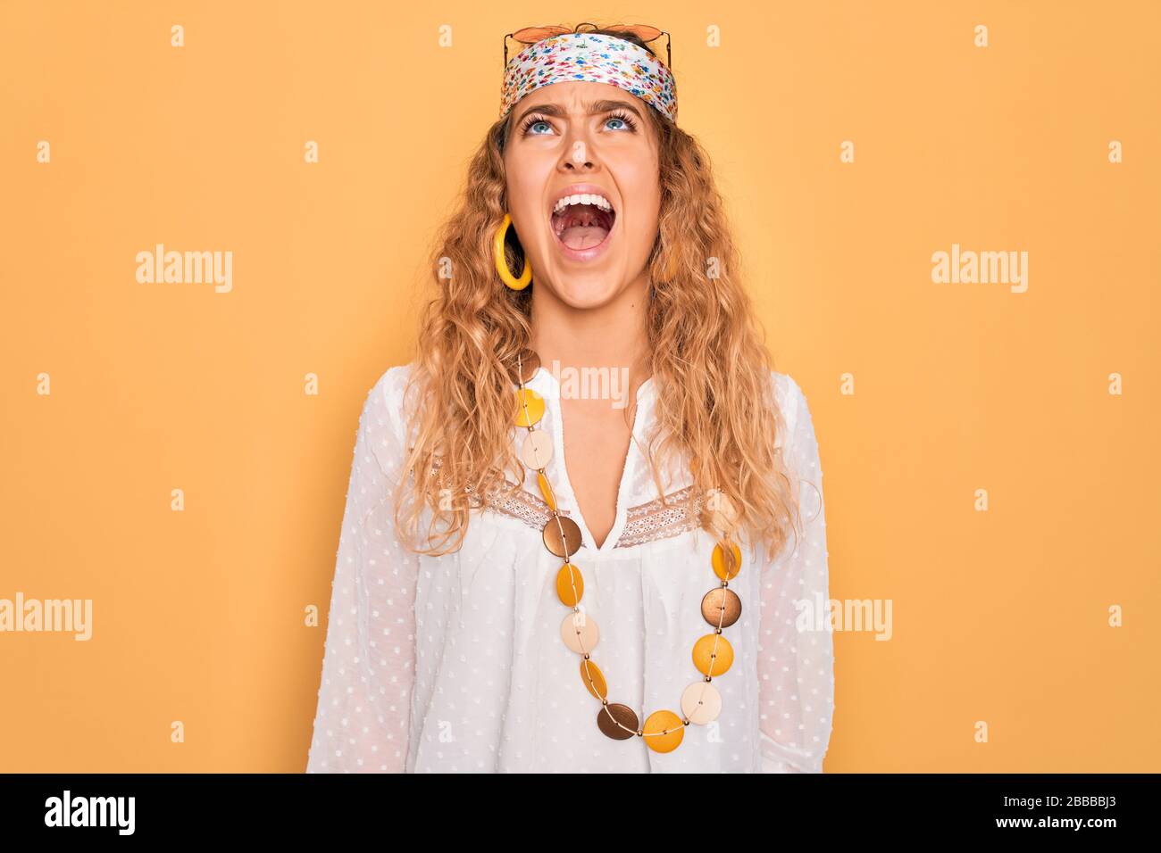 Young beautiful blonde hippie woman with blue eyes wearing sunglasses ...