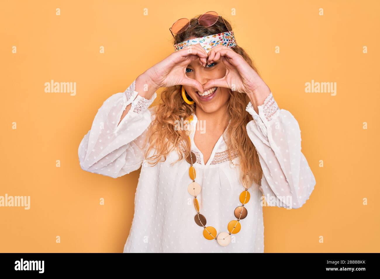 Young beautiful blonde hippie woman with blue eyes wearing sunglasses ...