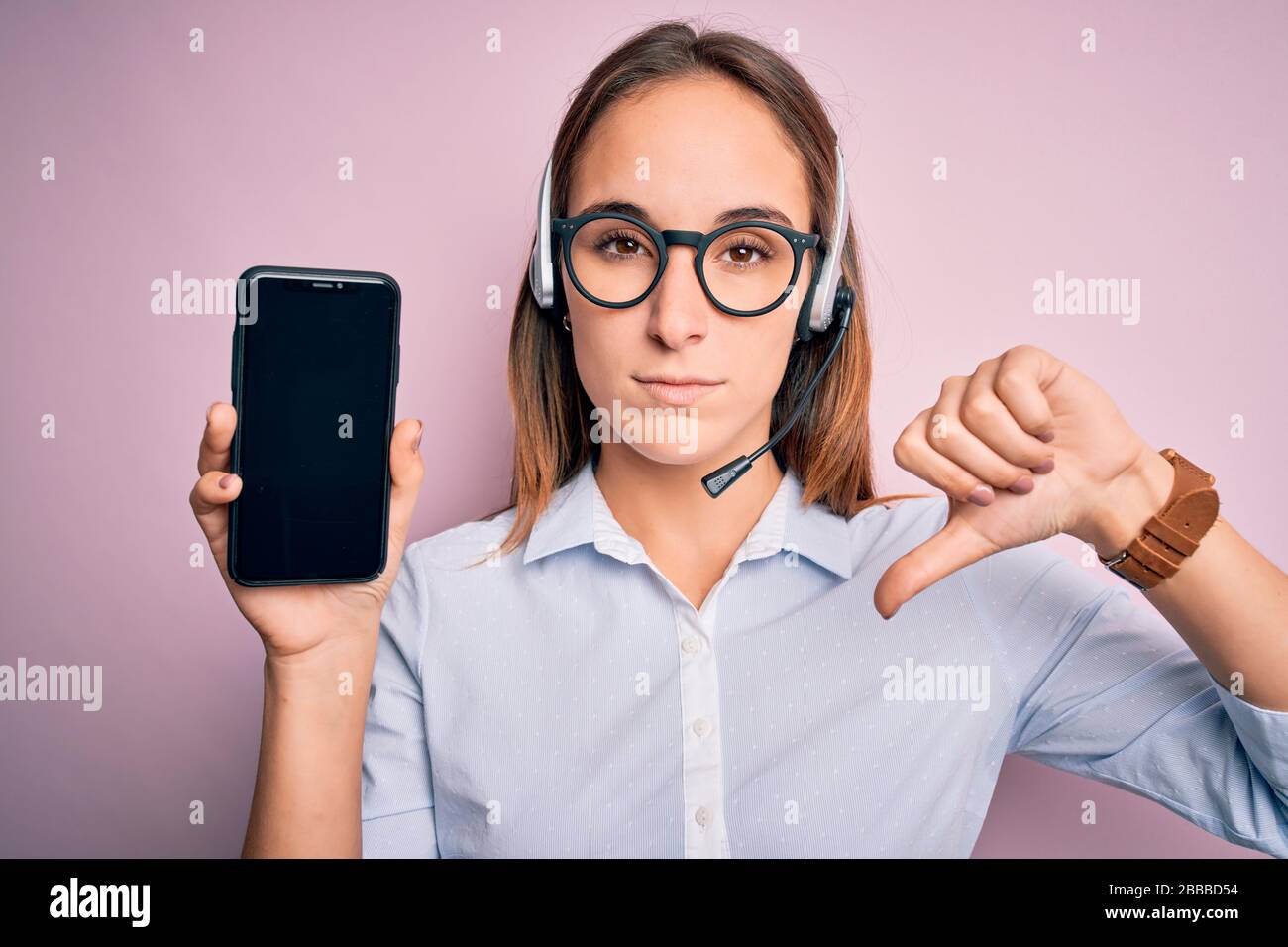 Beautiful call center agent woman working using headset holding ...