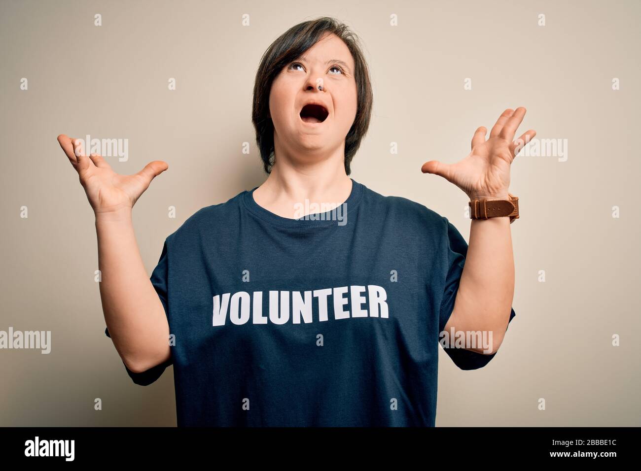 Young down syndrome volunteer woman wearing social care charity t-shirt ...