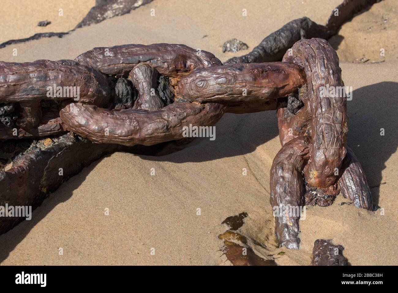 Old rusty chain in sand on beach Stock Photo - Alamy