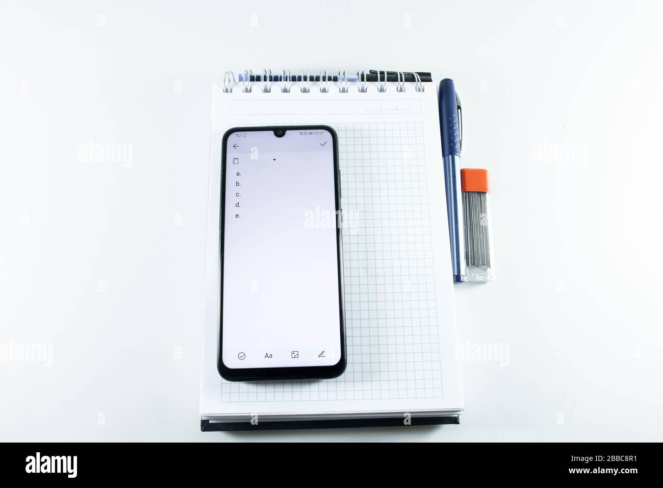 Concept of notepad phone pen. The photo was taken on white background ...