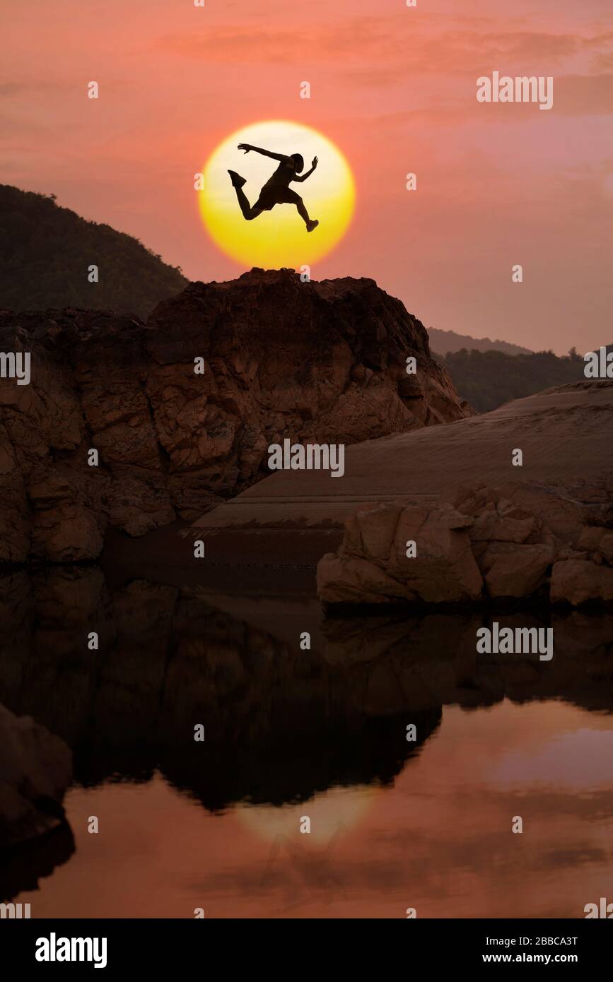 sportman running on top of mountain with sunset or sunrise background ...
