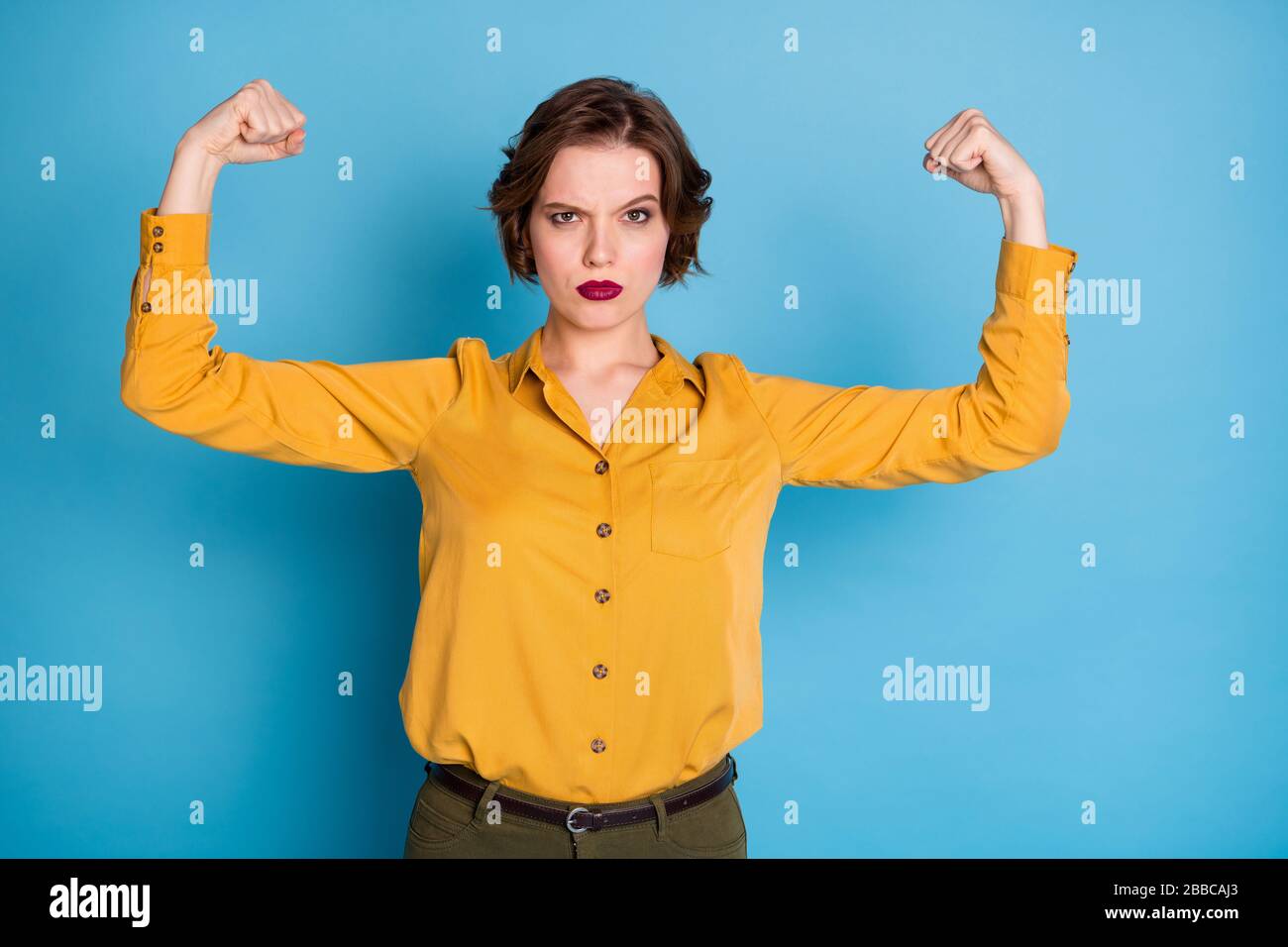 Girls power. Photo of pretty serious lady hold raise biceps two hands ...