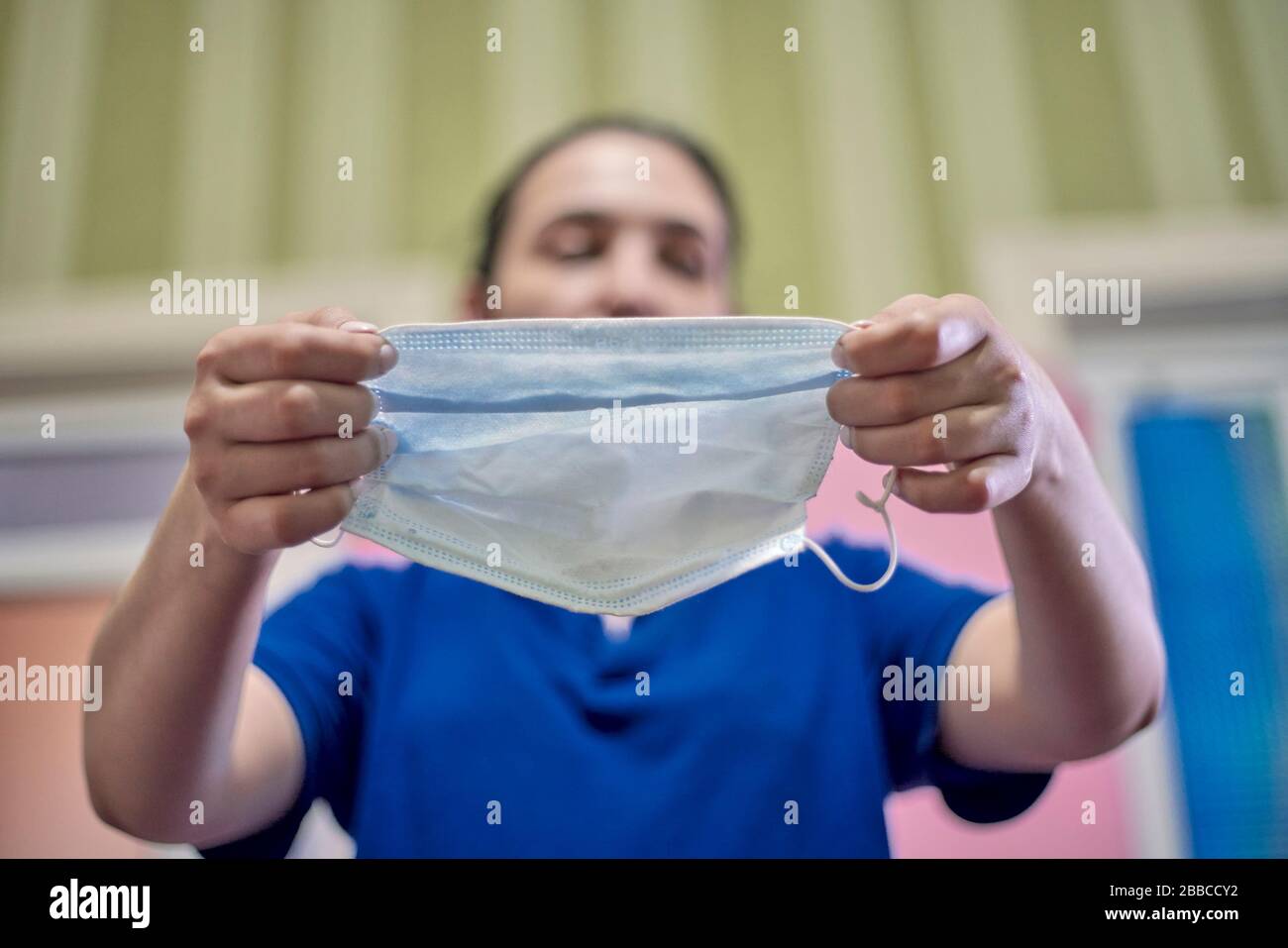 A mother wearing protective mask for her kid to protection from flu or ...