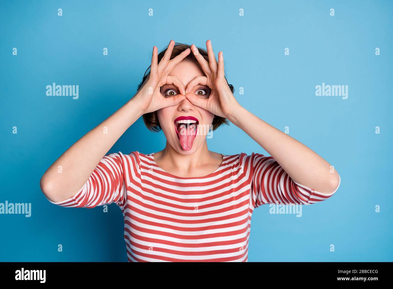 Photo of pretty cheerful crazy lady making fingers specs shape near ...
