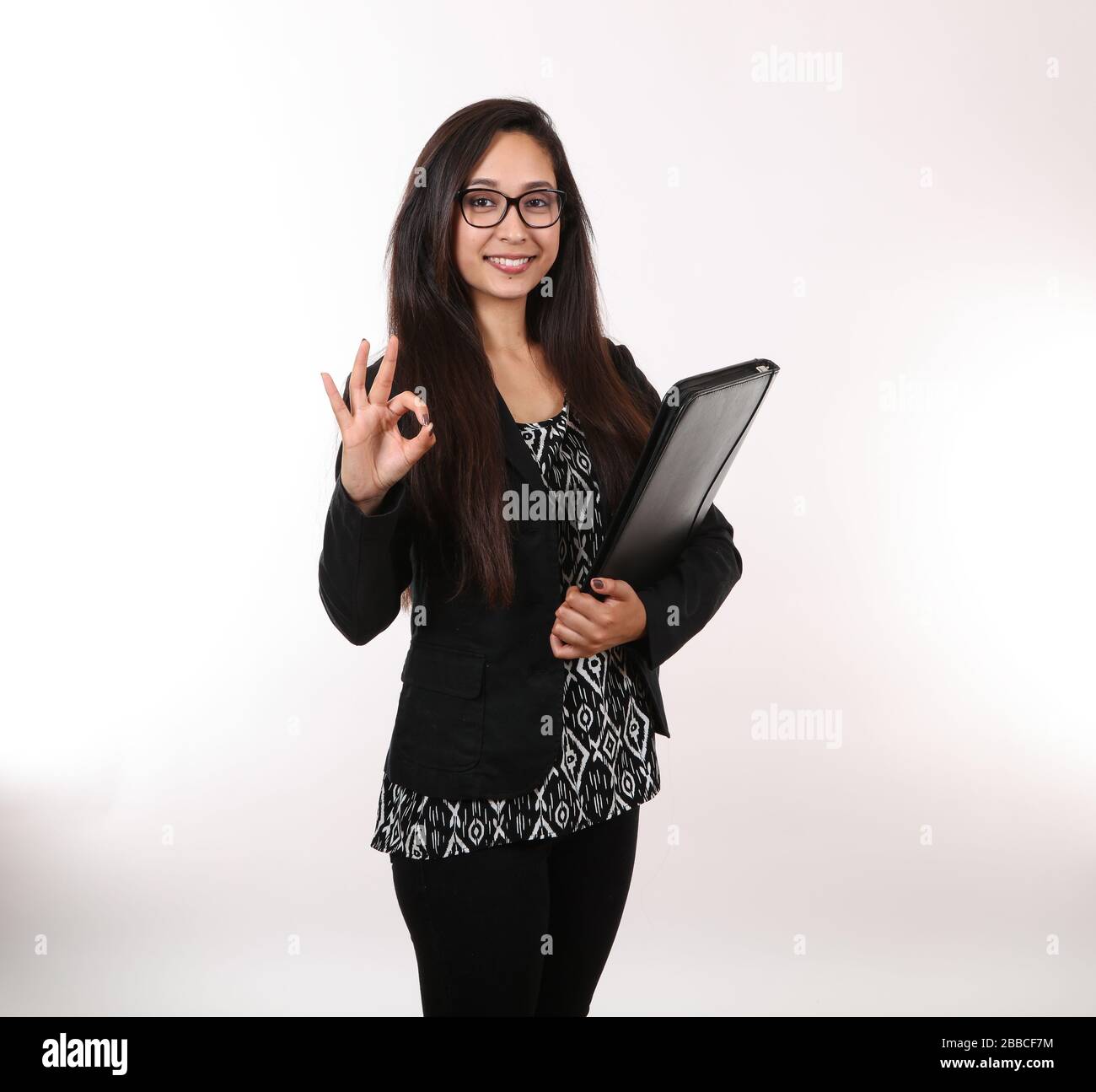 A young business woman holds up the okay sign Stock Photo - Alamy