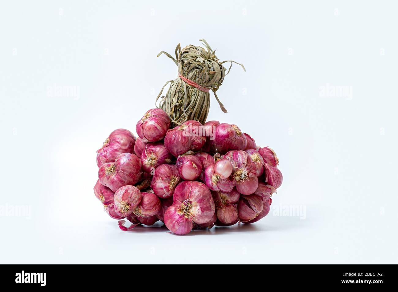 Raw bundle shallot onions on white background Stock Photo - Alamy