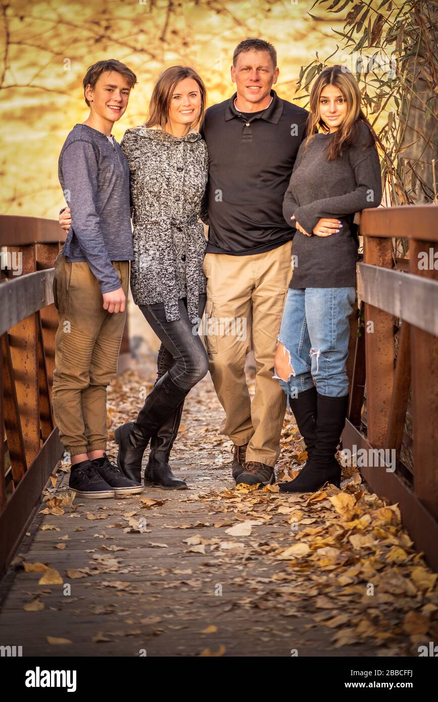 Portrait of parents and their teenage children smiling, standing and ...