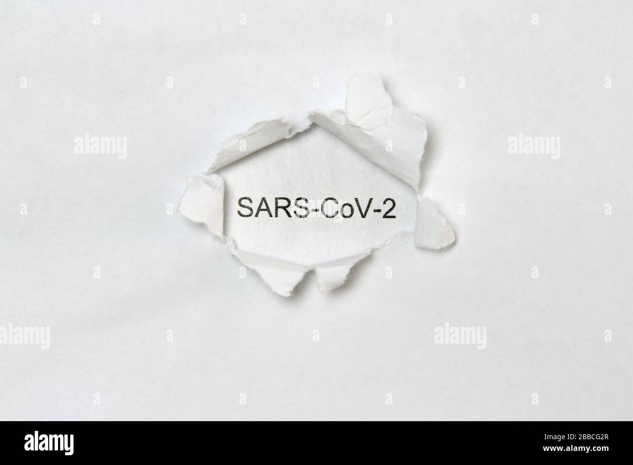 The word sars-cov-2 printed in black letters on a white sheet of paper ...