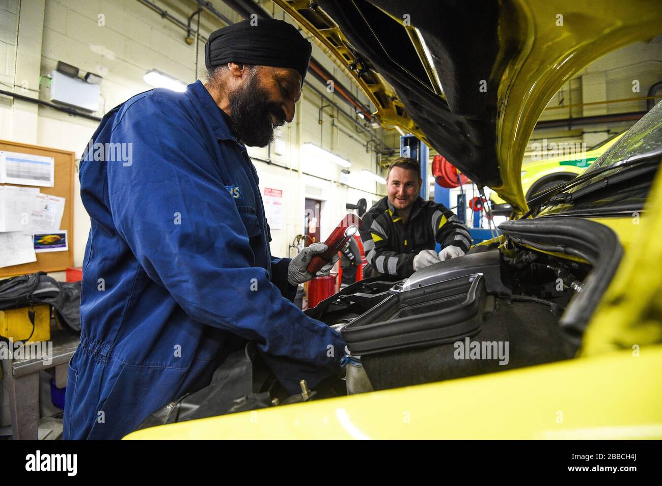 An NHS mechanic and an AA mechanic check the engine of an ambulance, at ...