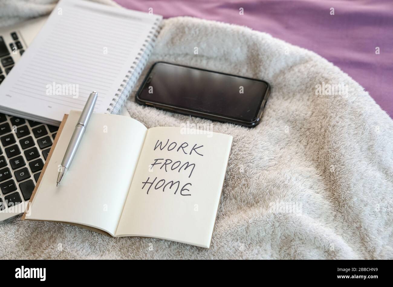 Work from home, text written on notepad. Computer laptop, cellphone and ...
