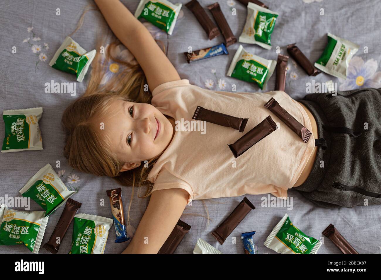Changxing, China - March 31, 2020: Cute little girl with junk foods ...