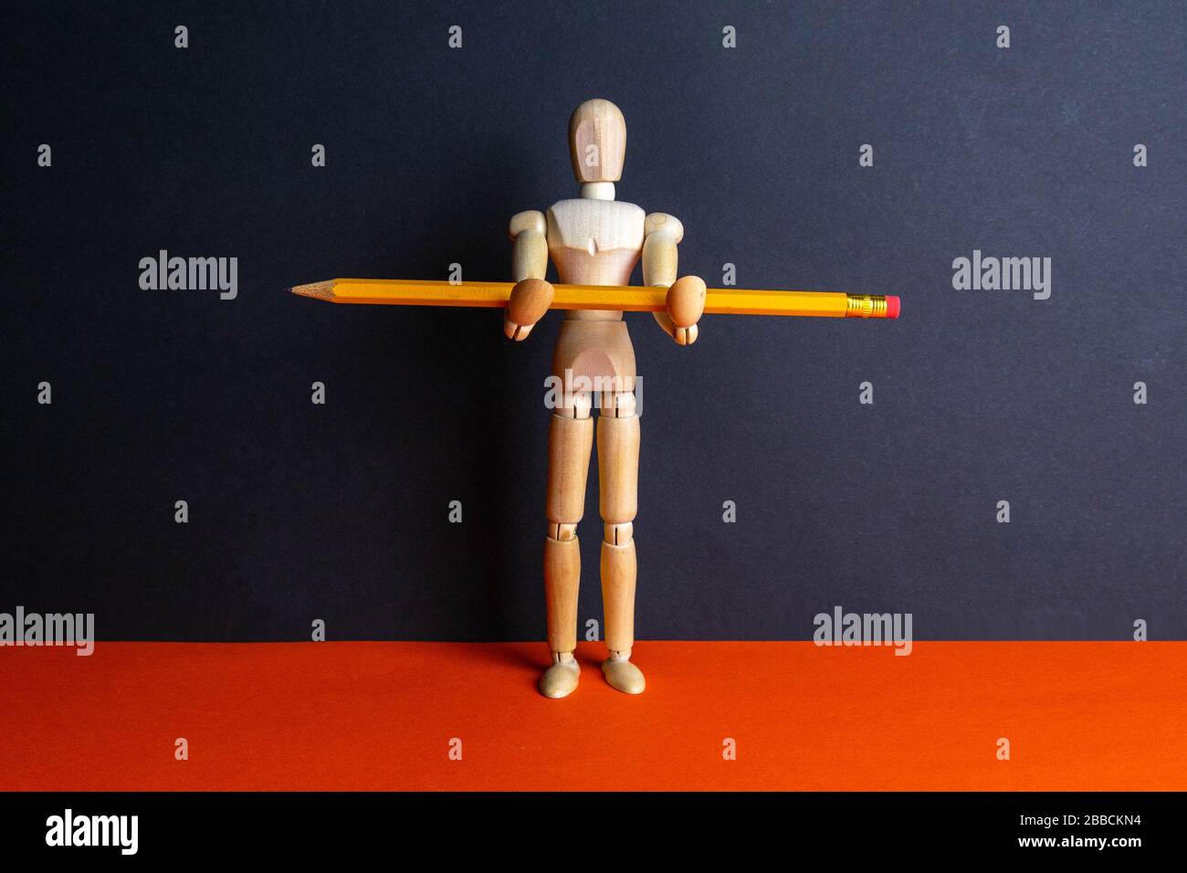 The figure of a wooden man holds pencil. Front views Stock Photo - Alamy