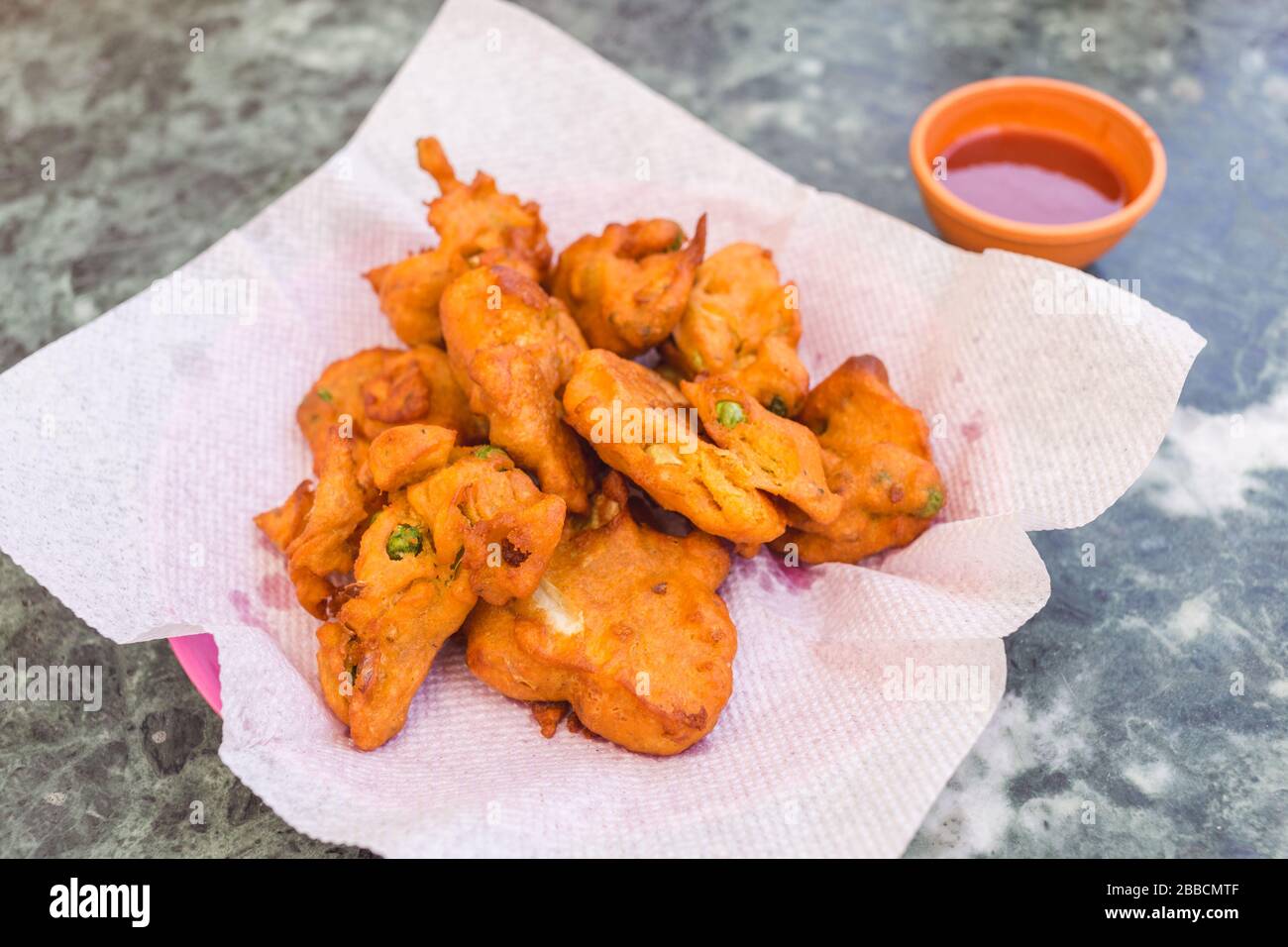 A pile of Pakora snacks on a table in India. This is a typical fried ...