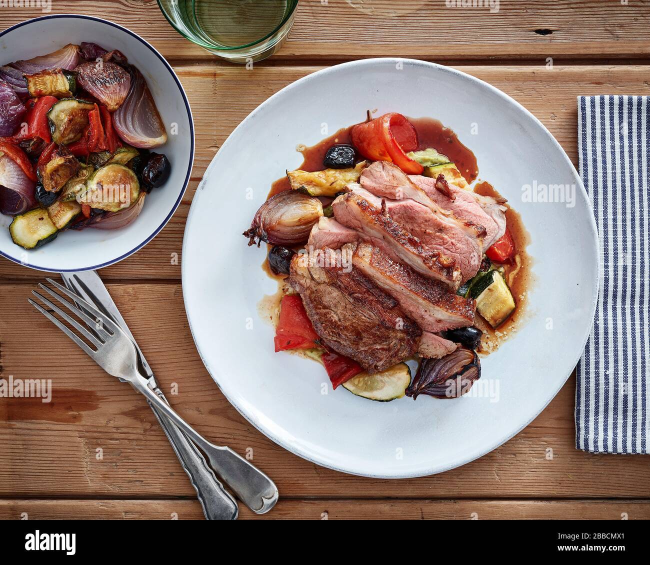 Lamb rump roast vegetables Mediterranean jus gravy overhead pink ...