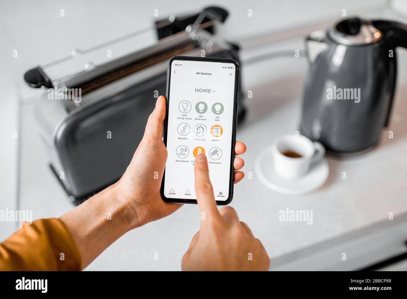 Controlling smart kitchen appliance using mobile phone at home, close ...