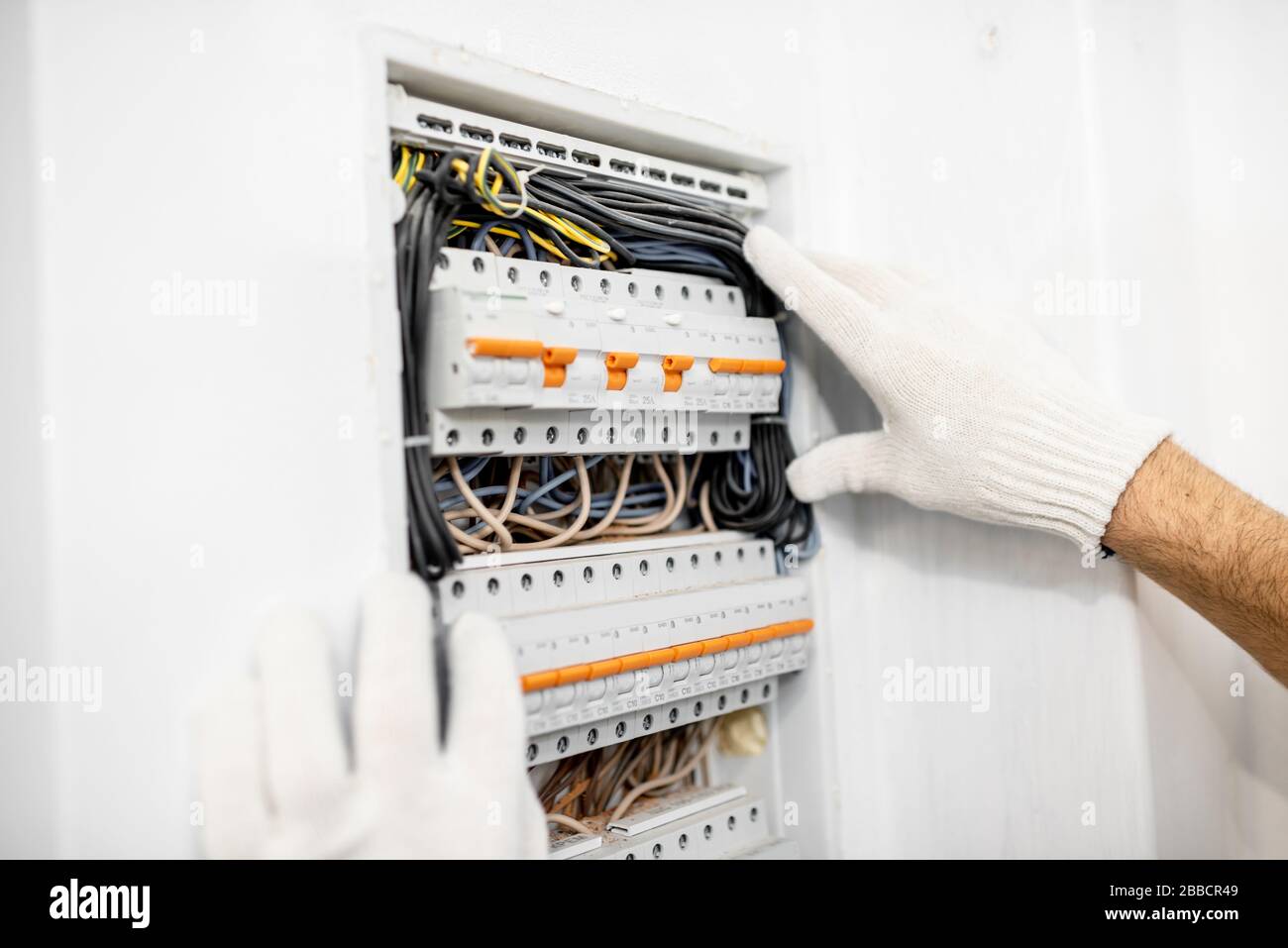 Electrician installing or repairing apartment electrical panel, close ...