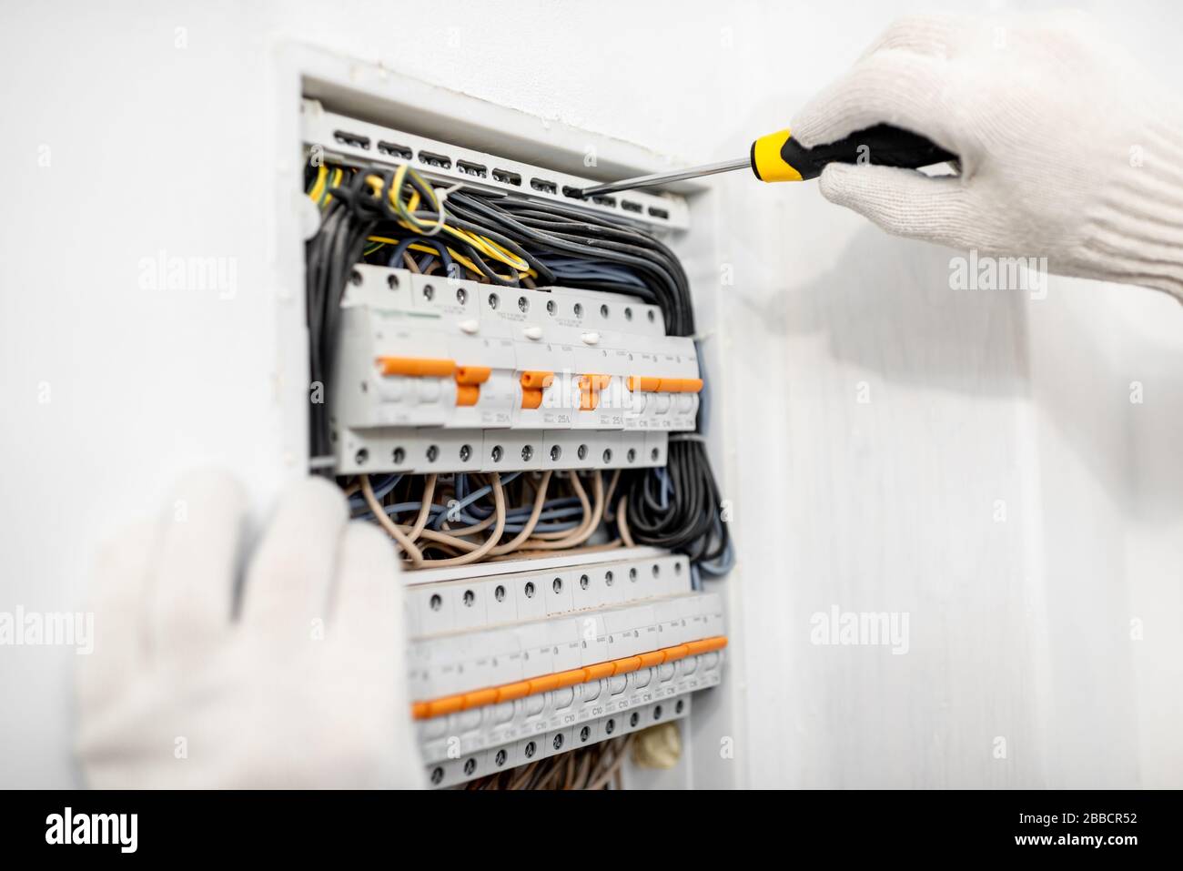 Electrician installing or repairing apartment electrical panel, close ...
