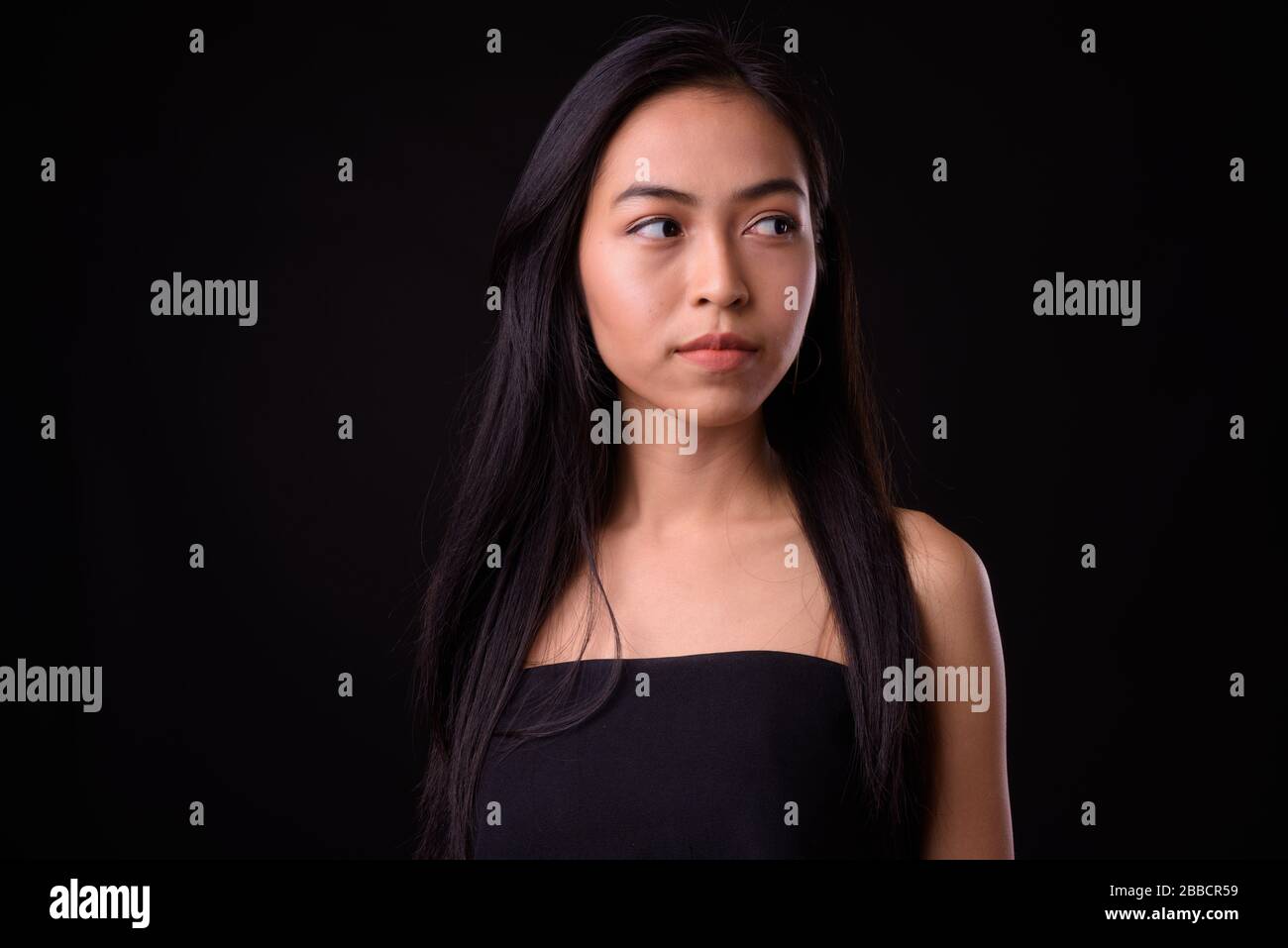 Face of young beautiful Asian woman thinking Stock Photo - Alamy