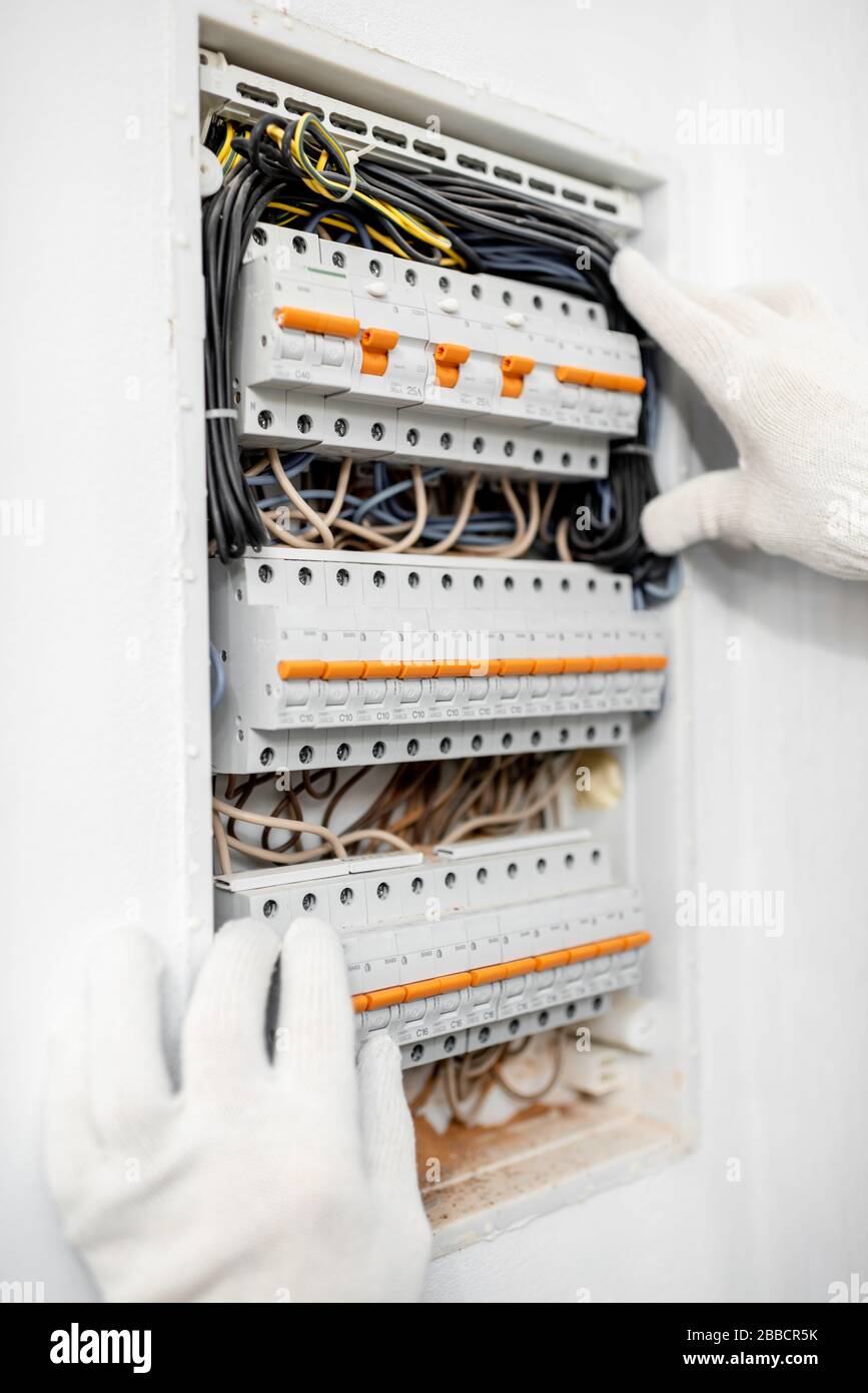 Electrician installing or repairing apartment electrical panel, close ...