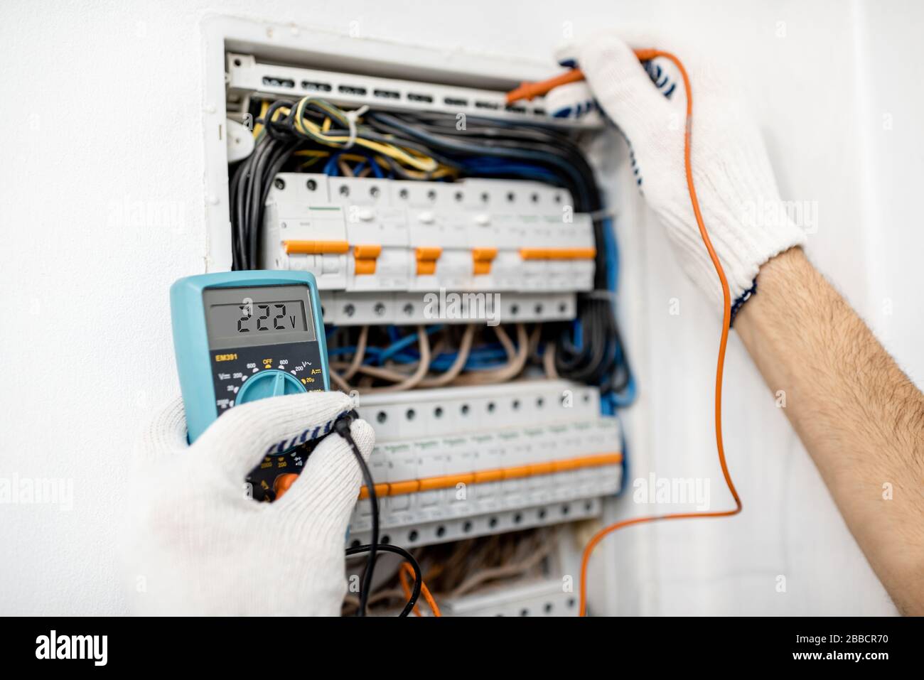 Electrician installing or repairing apartment electrical panel, close ...