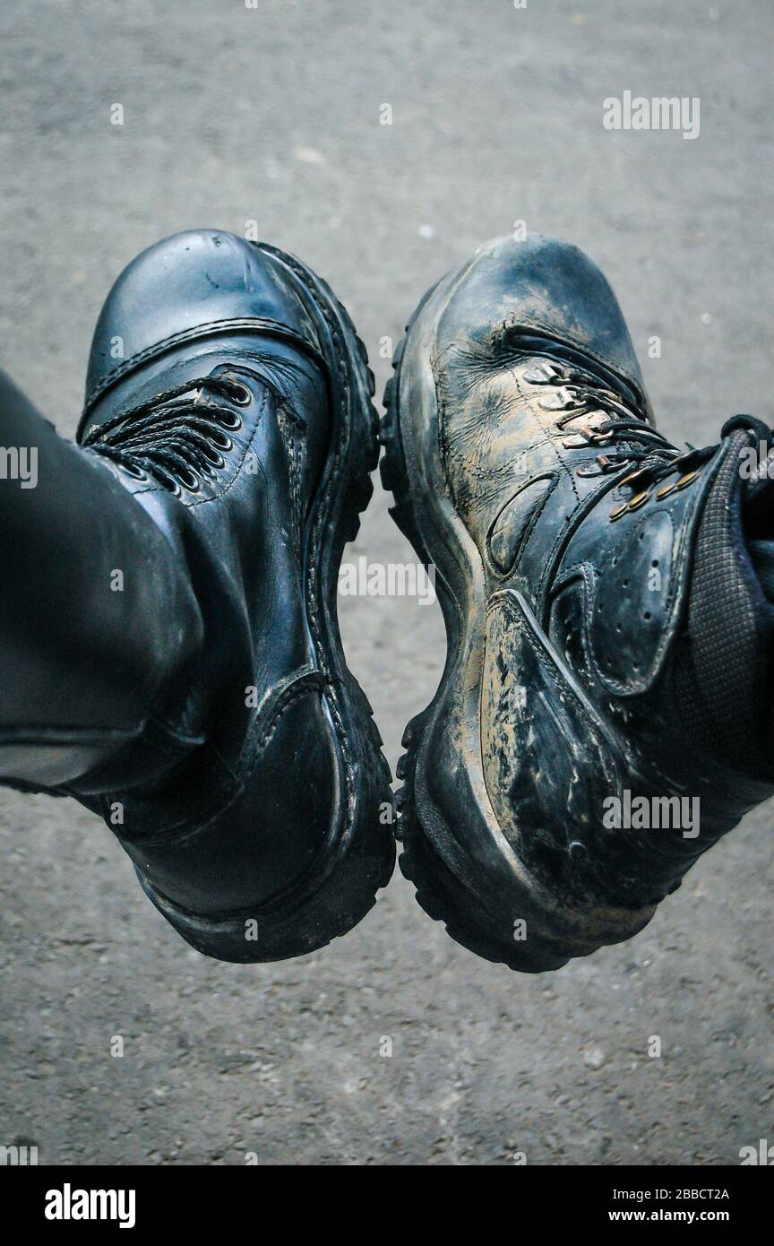 Two black boots. Muddy boots side by side from a man and a woman Stock ...