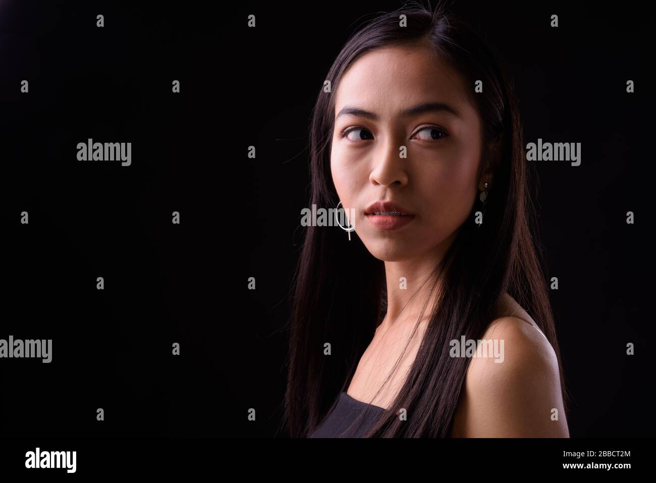 Face of young beautiful Asian woman looking back Stock Photo - Alamy