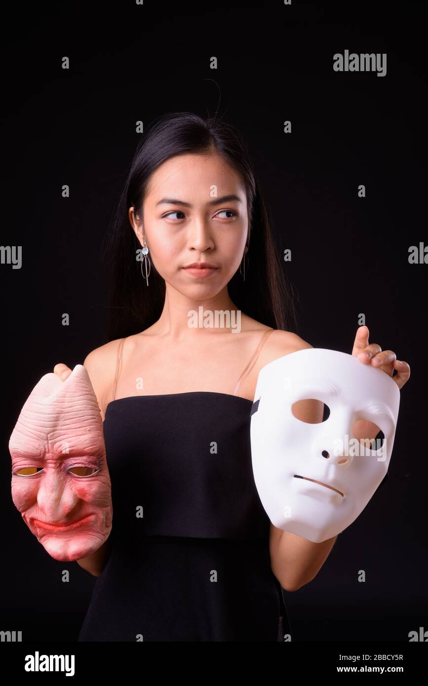 Portrait of young Asian woman choosing between two masks Stock Photo ...