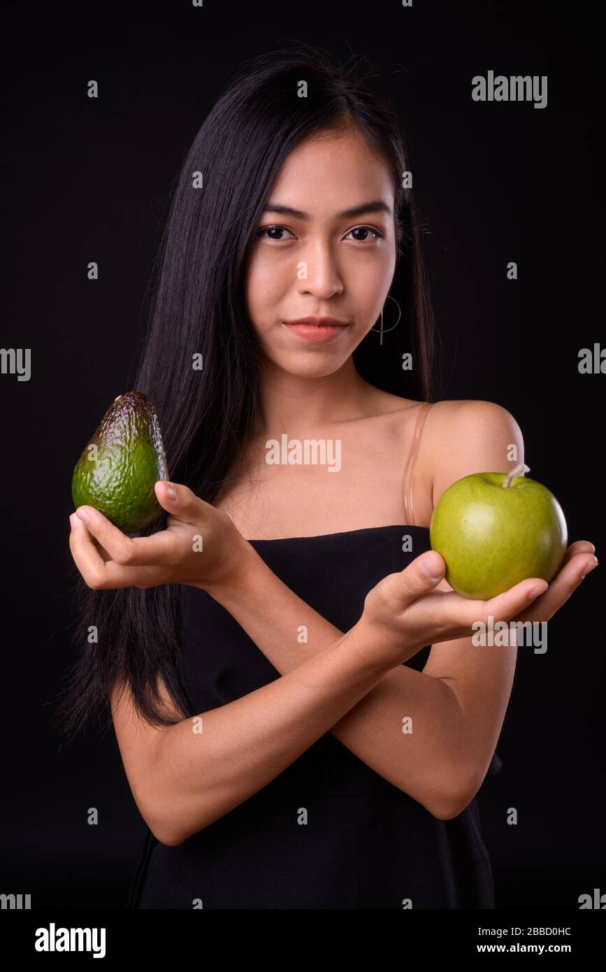 Portrait of young beautiful Asian woman with apple and avocado Stock ...