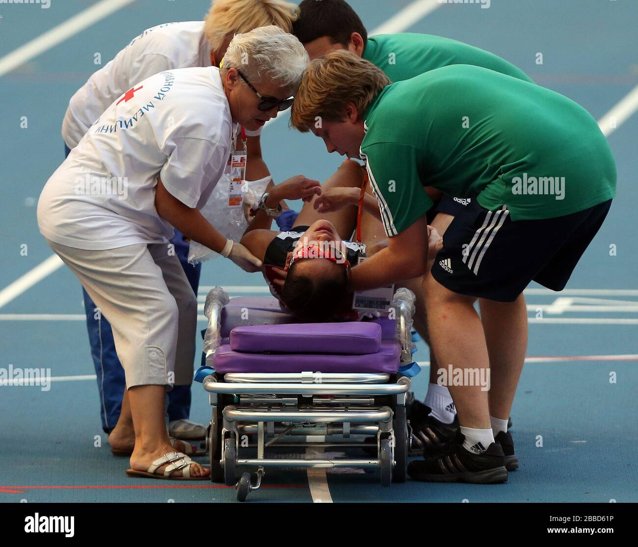 Hye-Song Kim of Korea is helped from the track after the marathon ...