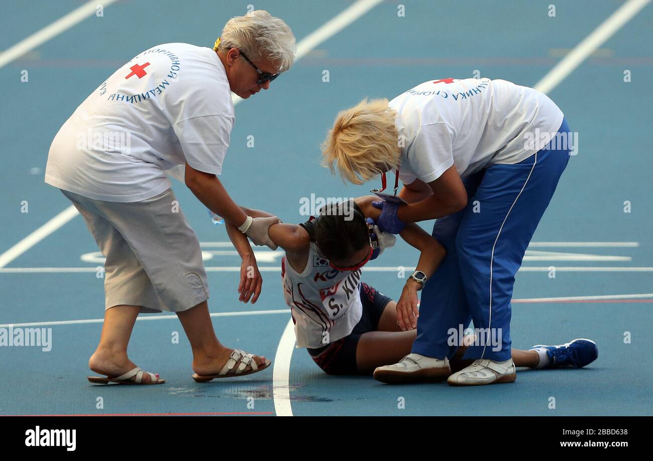 Hye-Song Kim of Korea is helped from the track after the marathon ...