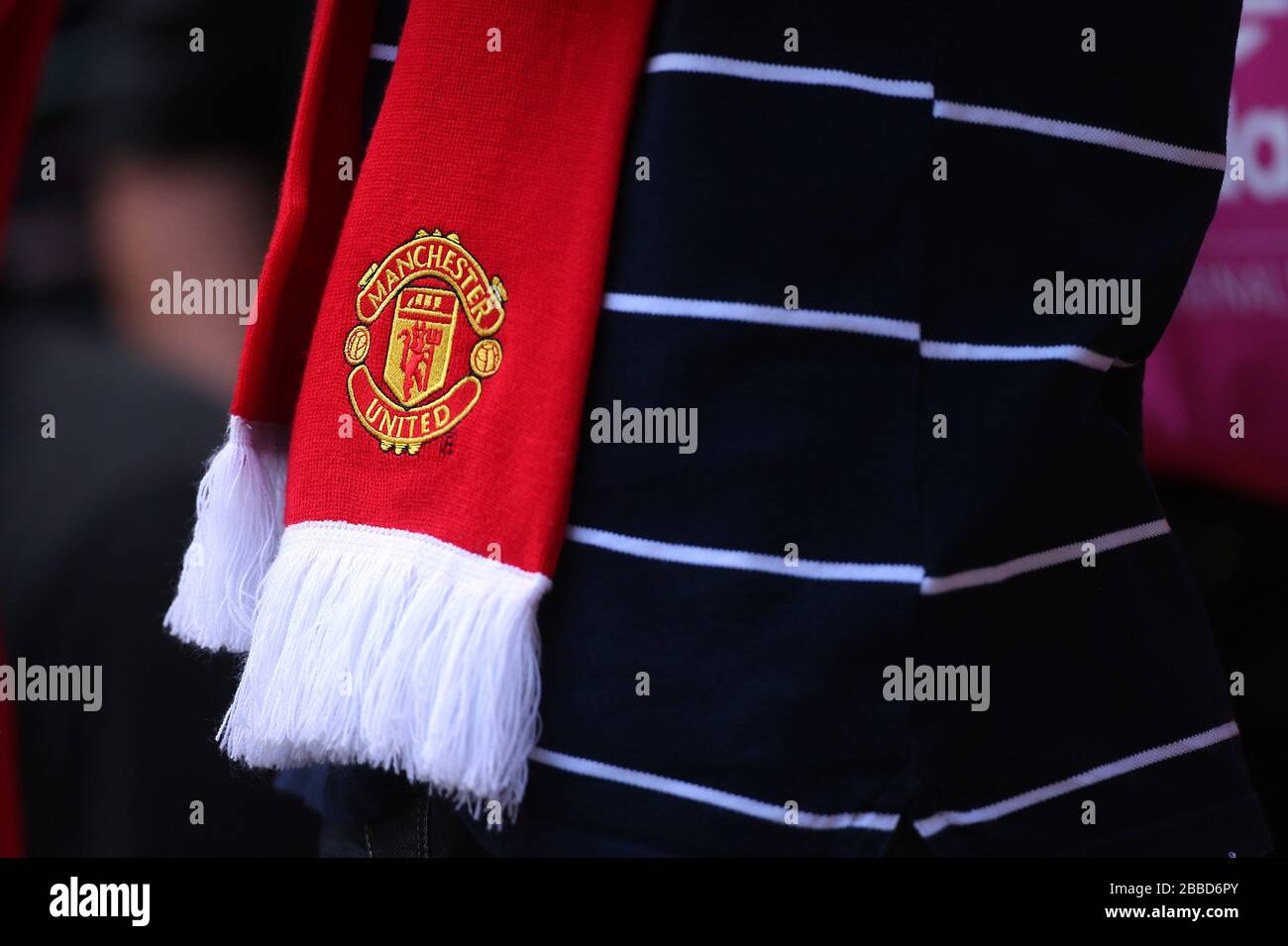 A view of a Manchester United scarf around the neck of a fan in the ...