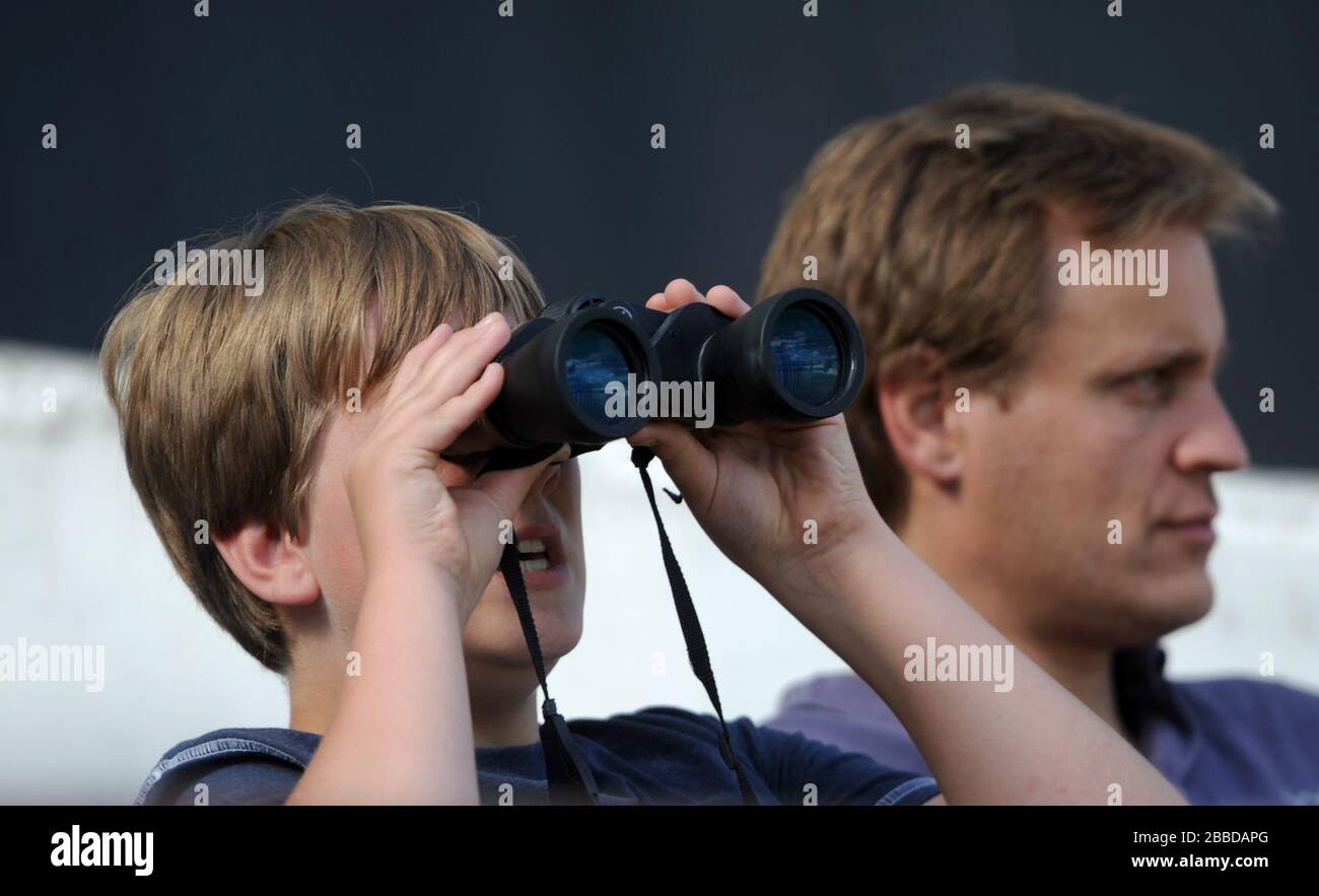 A fan watches the action through binoculars Stock Photo - Alamy