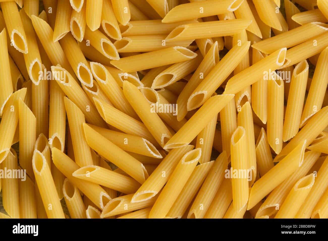 Food background - dry penne pasta, whole wheat uncooked ingredient ...