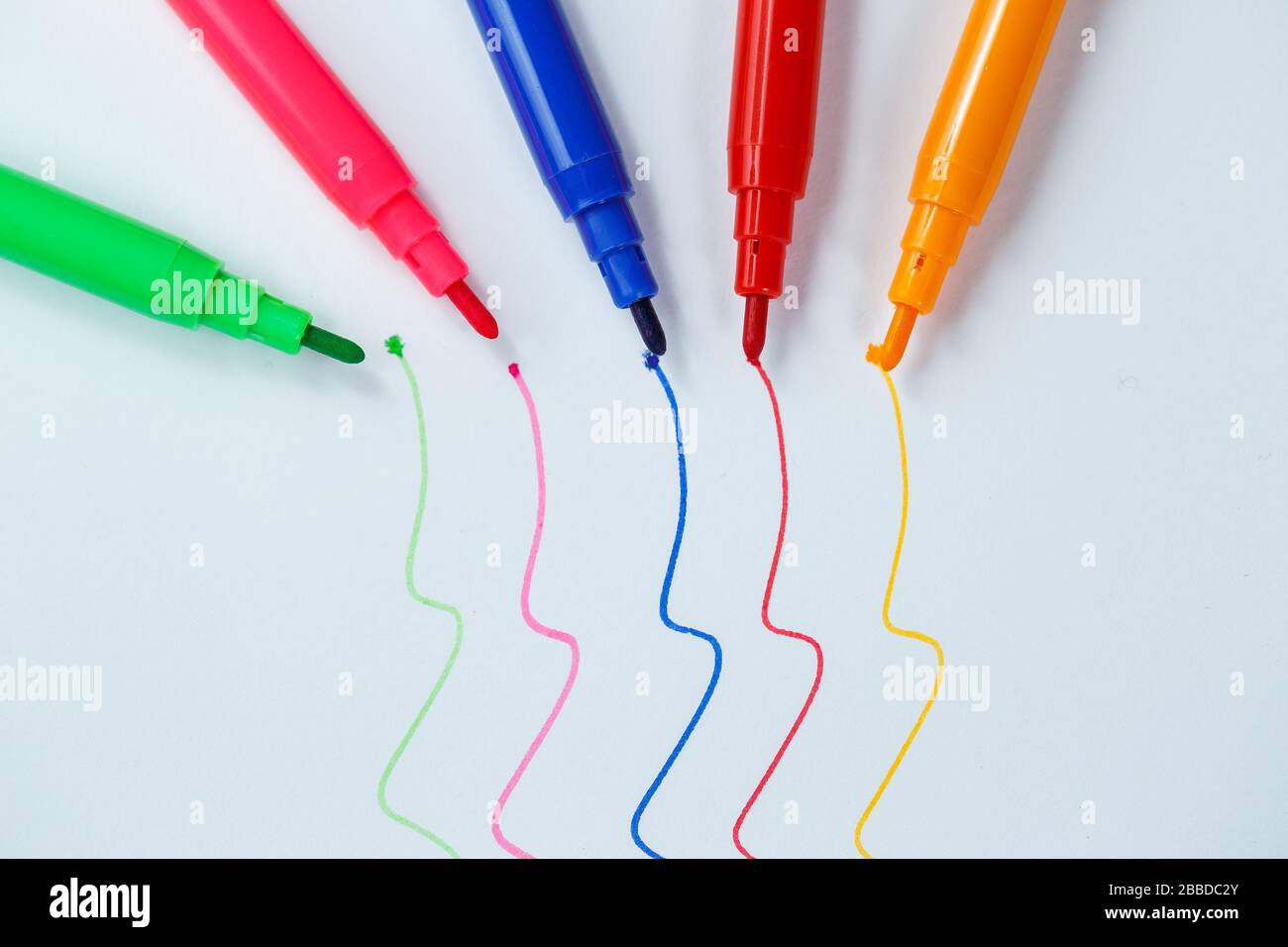 many multi-colored markers for drawing with drawings on white paper ...
