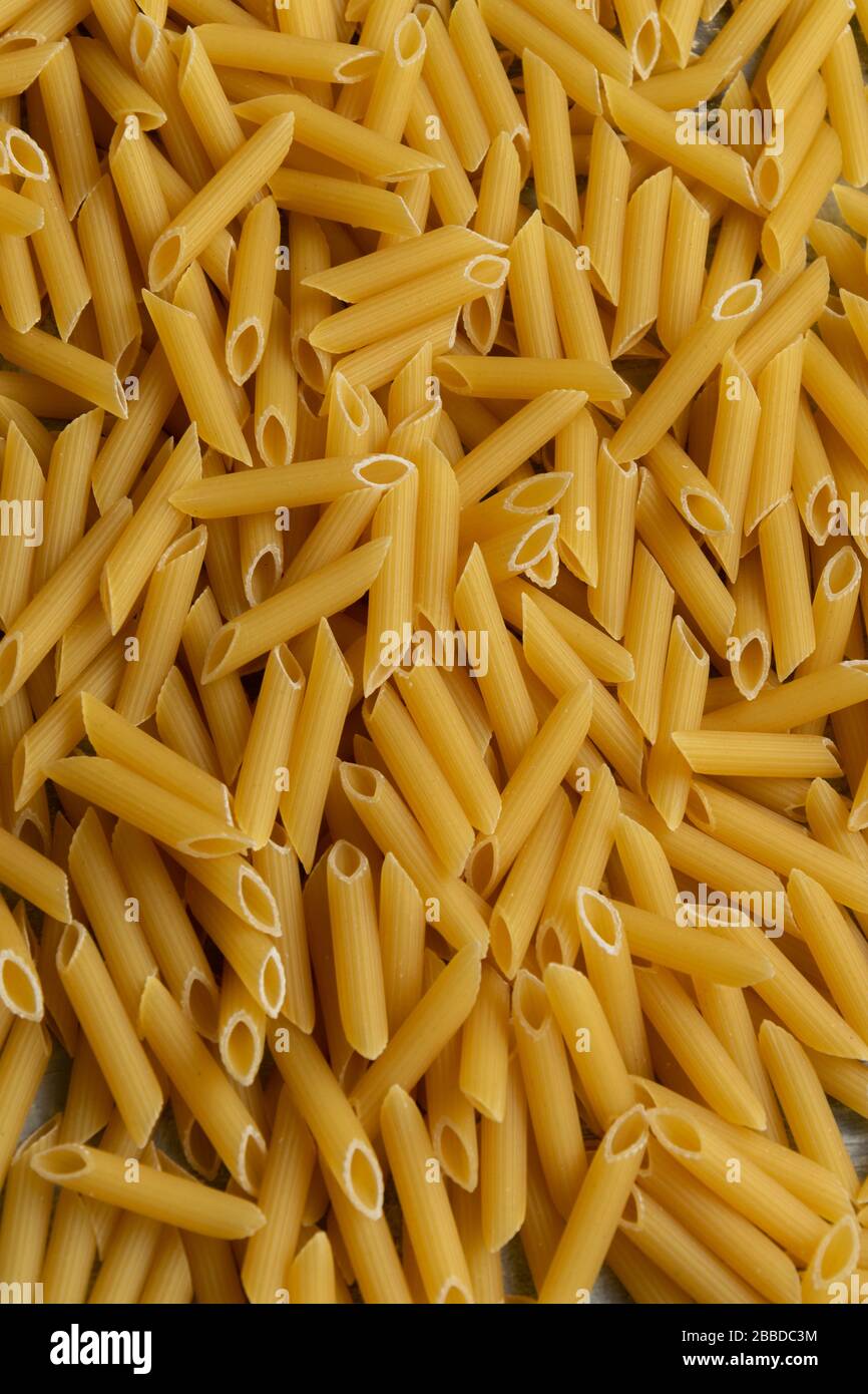 Food background - dry penne pasta, whole wheat uncooked ingredient ...