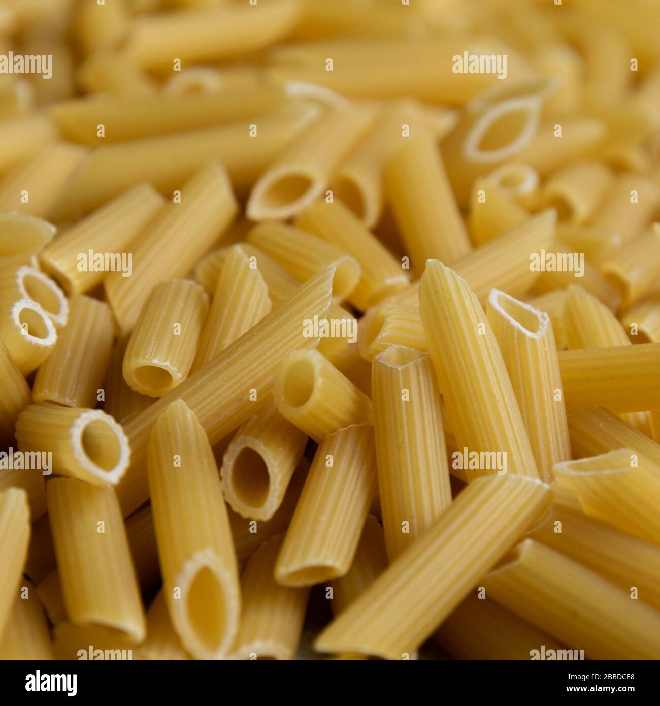 Food background - dry penne pasta, whole wheat uncooked ingredient ...