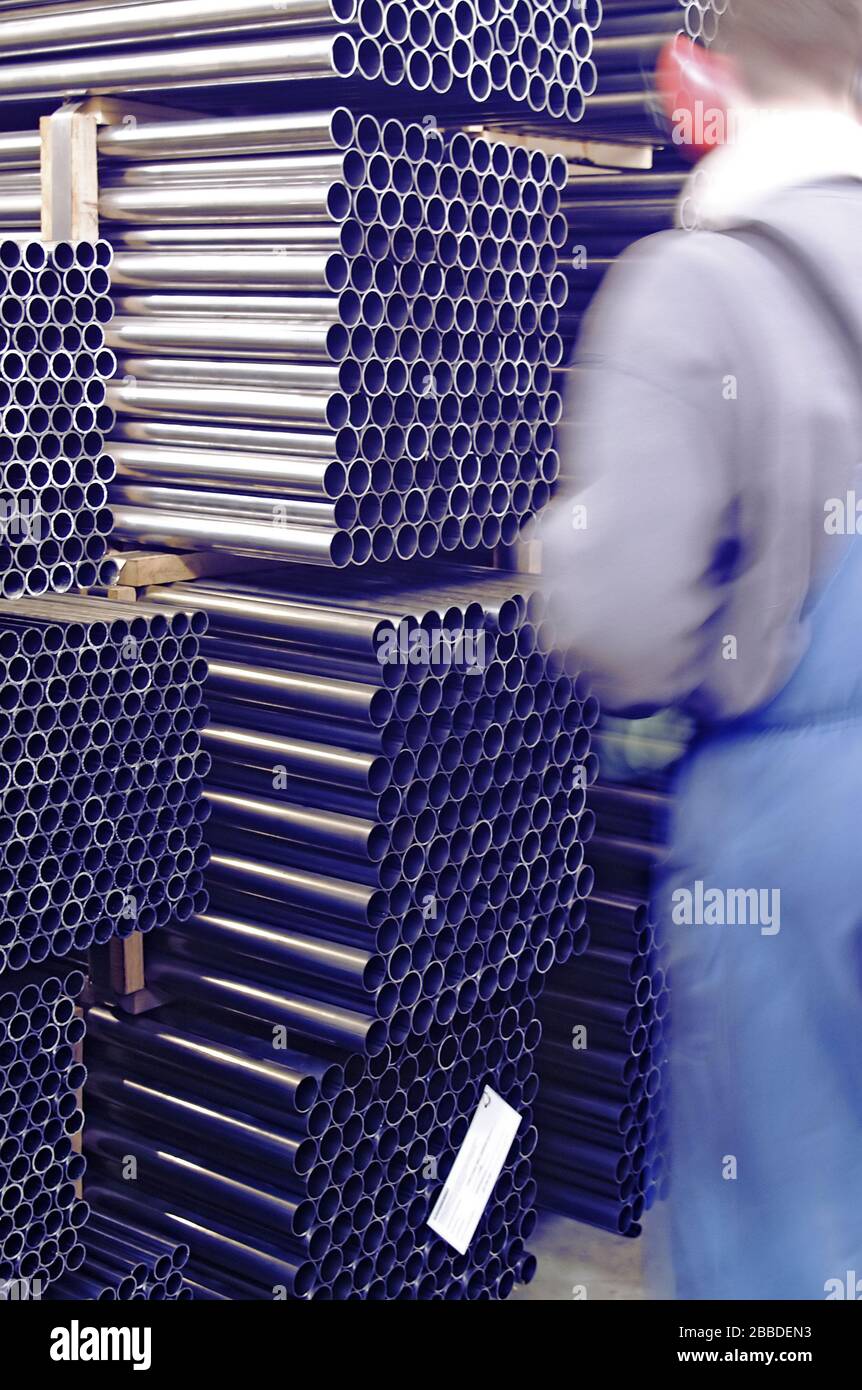 Warehouse worker is checking the stocks of steel pipes Stock Photo - Alamy