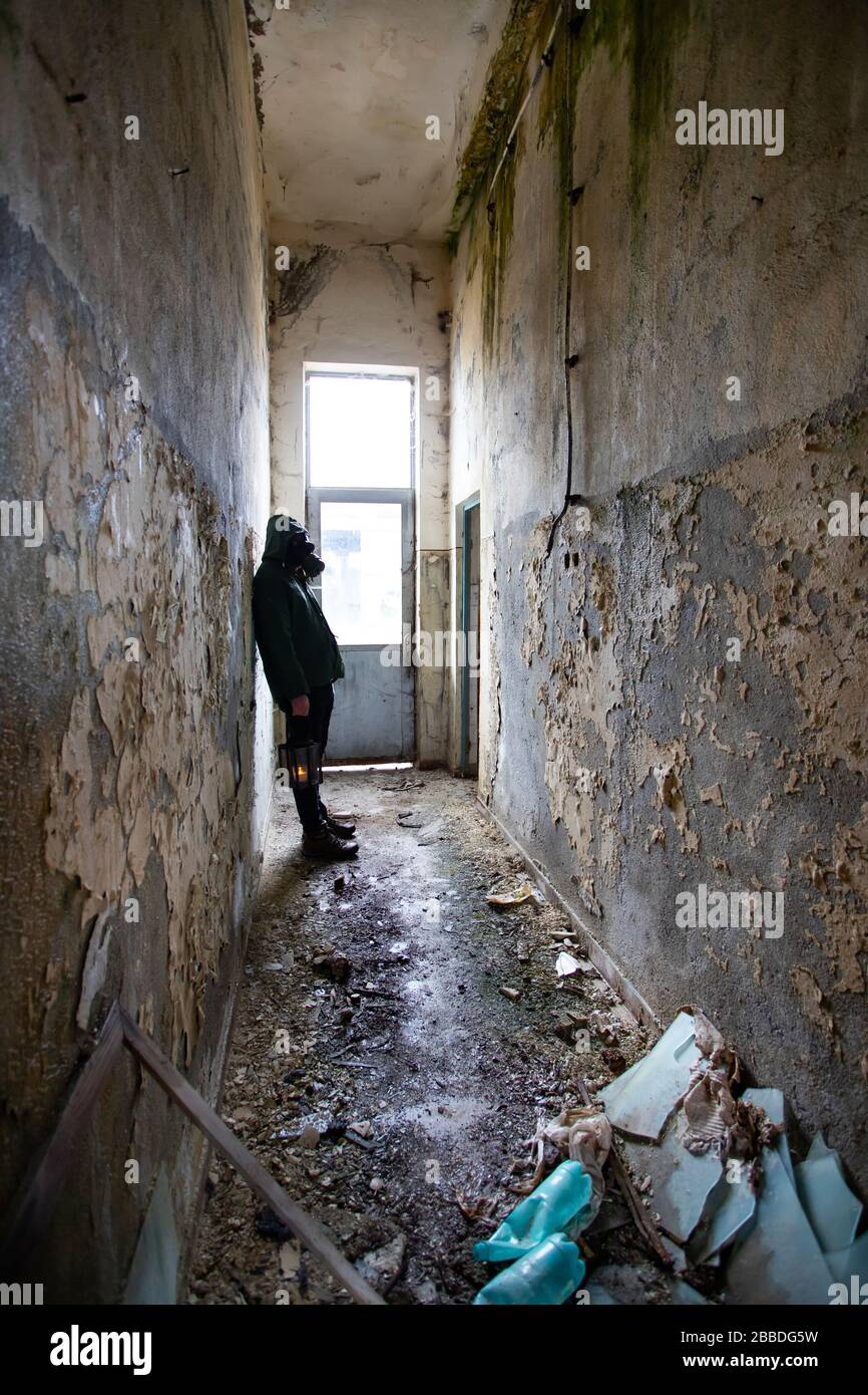 Post apocalyptic survivor in gas mask in a ruined building ...