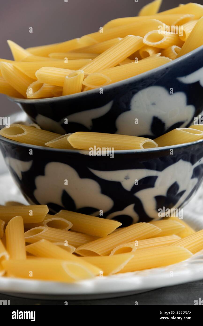 Raw penne pasta on blue background hi-res stock photography and images ...